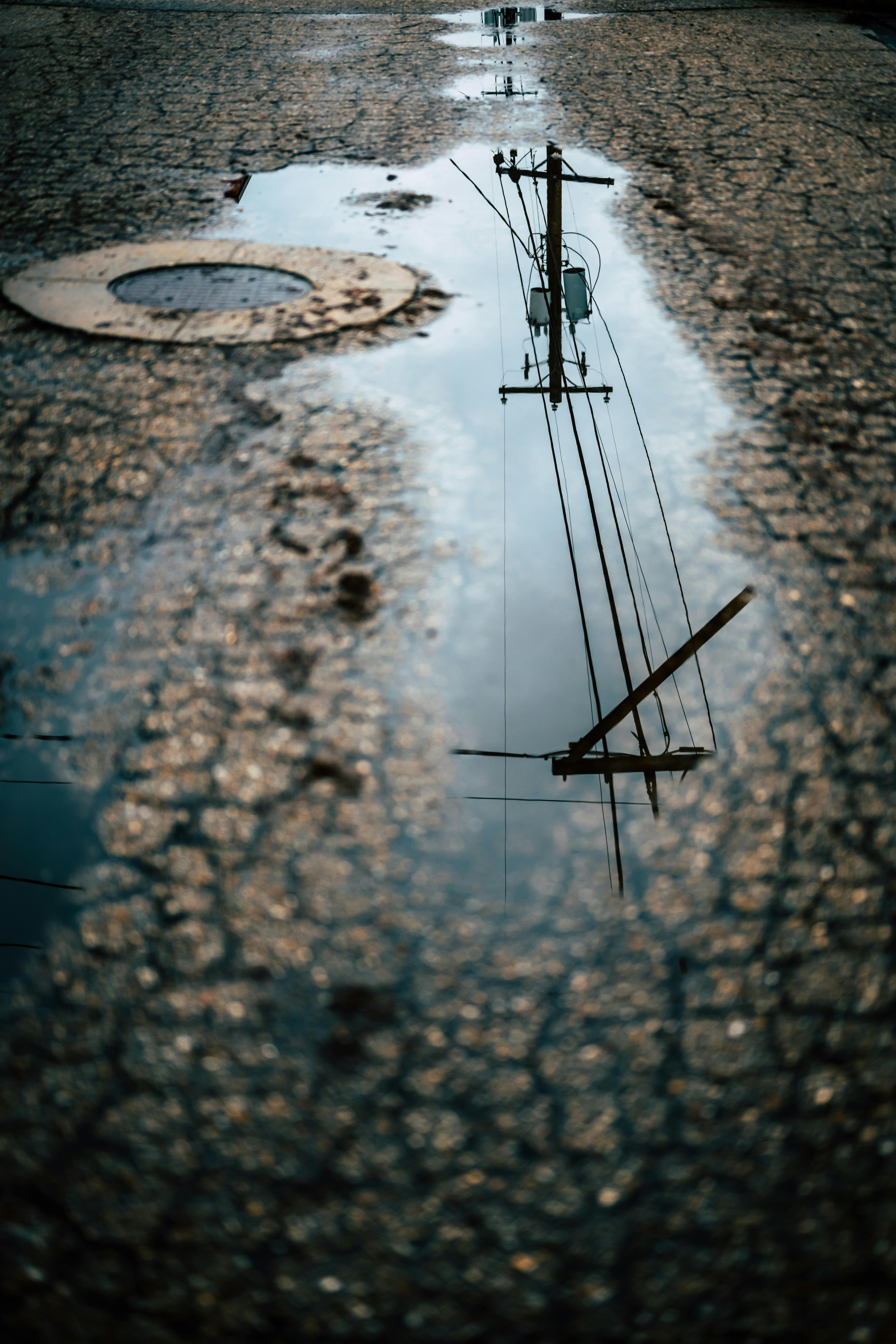 Reflection of Power Lines in Urban Puddle · Free Stock Photo