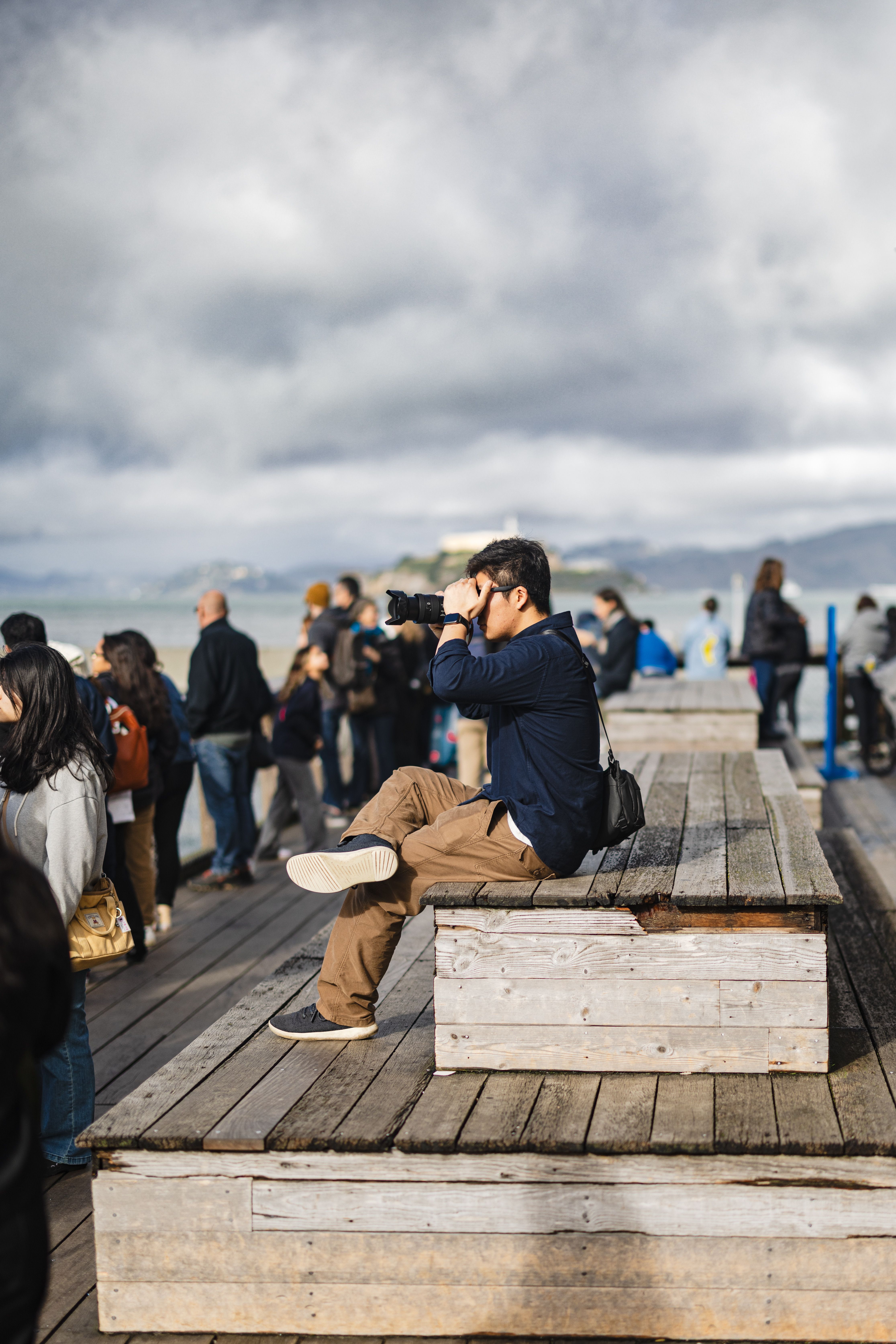 Photographer on a Busy Outdoor Pier Capturing Moments · Free Stock Photo