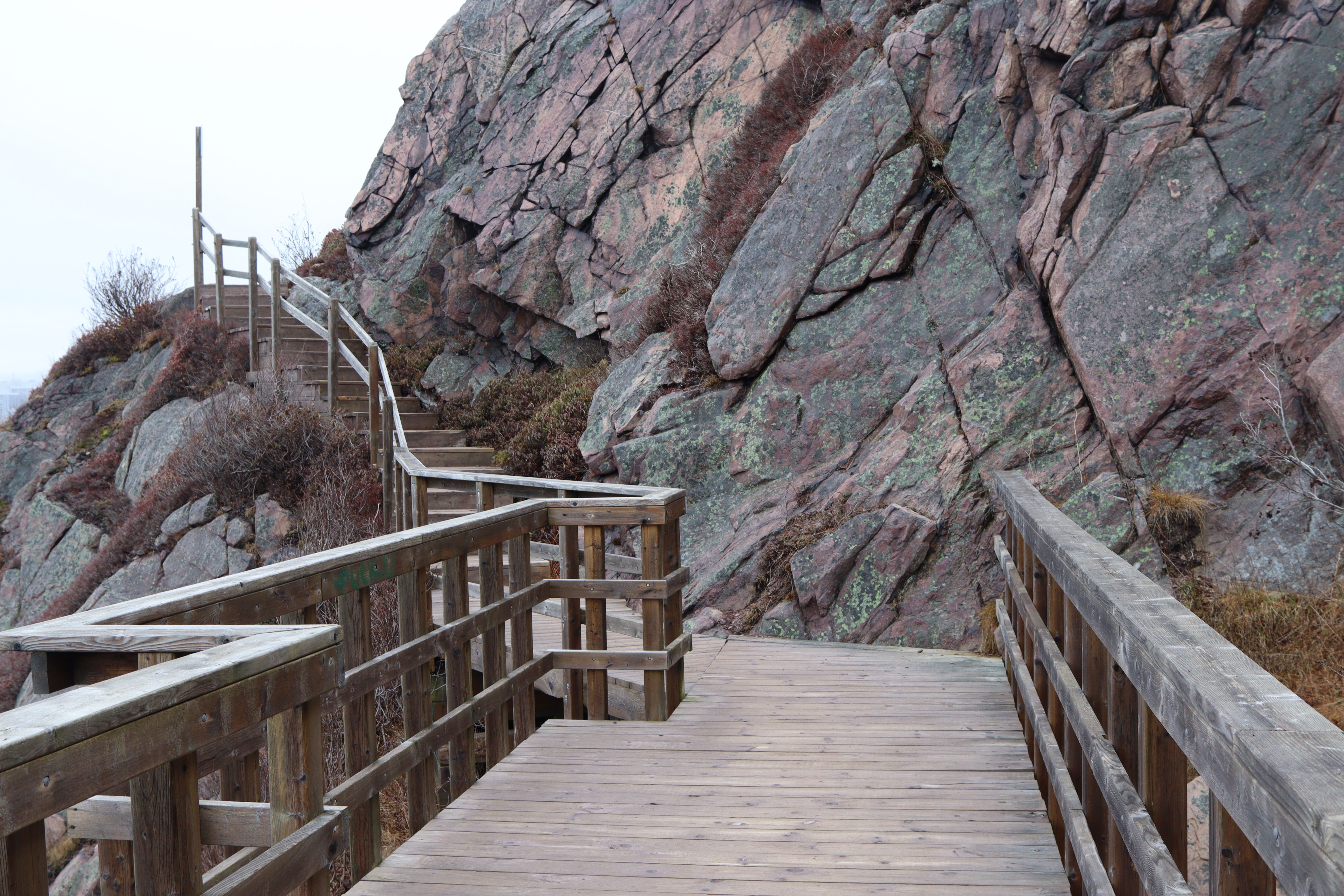 Wooden Pathway Along Rocky Cliff Side · Free Stock Photo