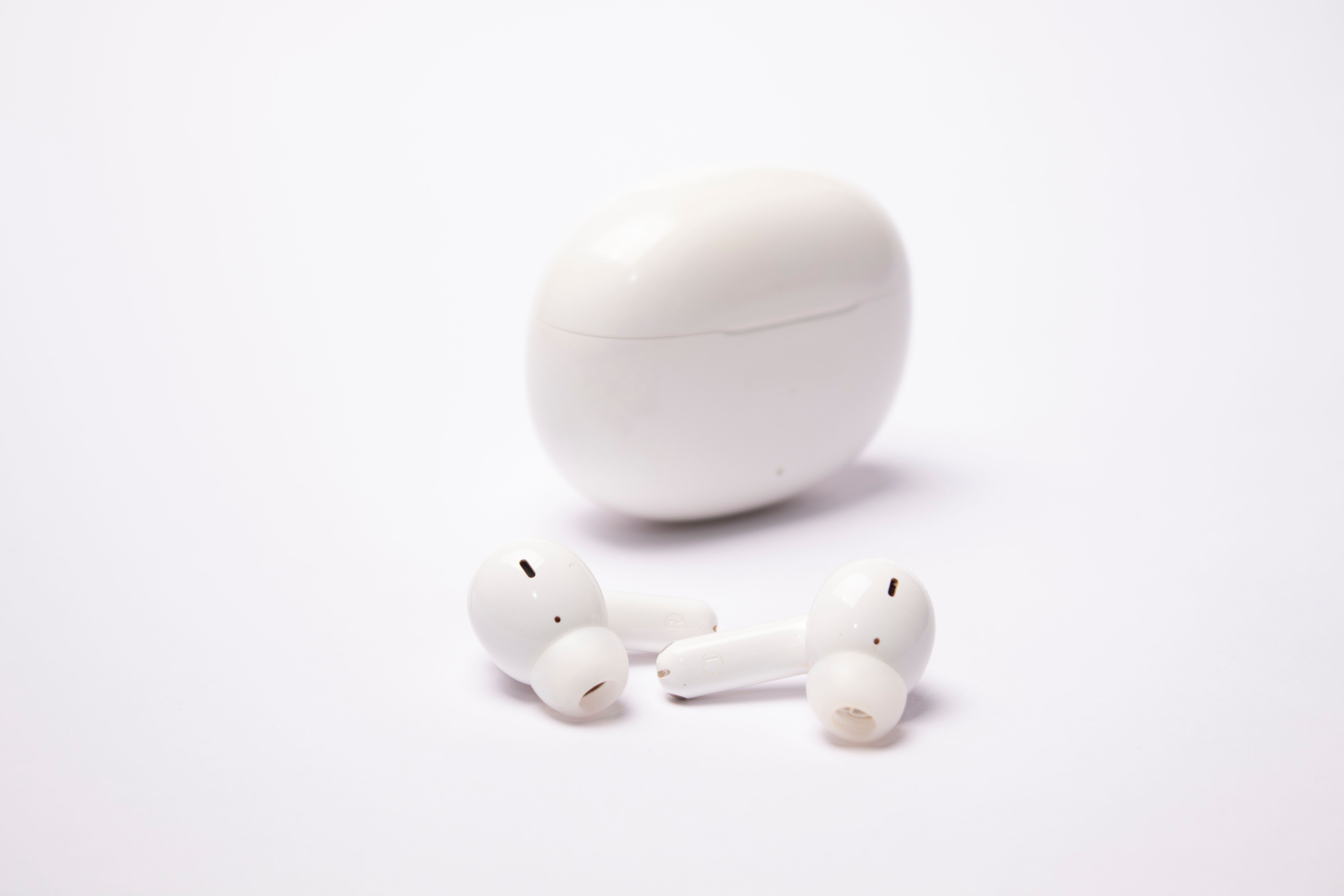 Minimalist White Wireless Earbuds on White Background · Free Stock Photo