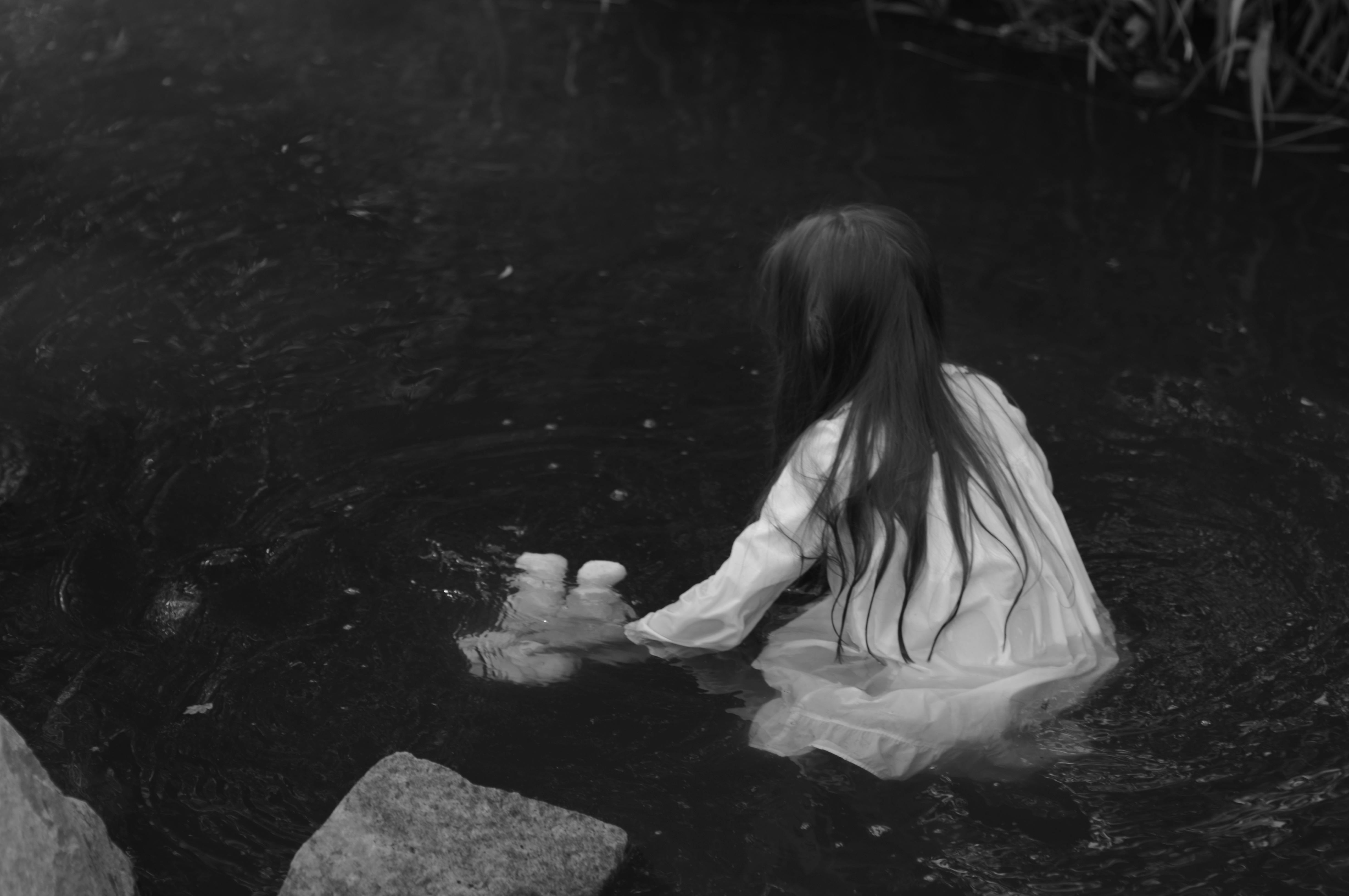 Child in White Dress Wading in Dark Water · Free Stock Photo