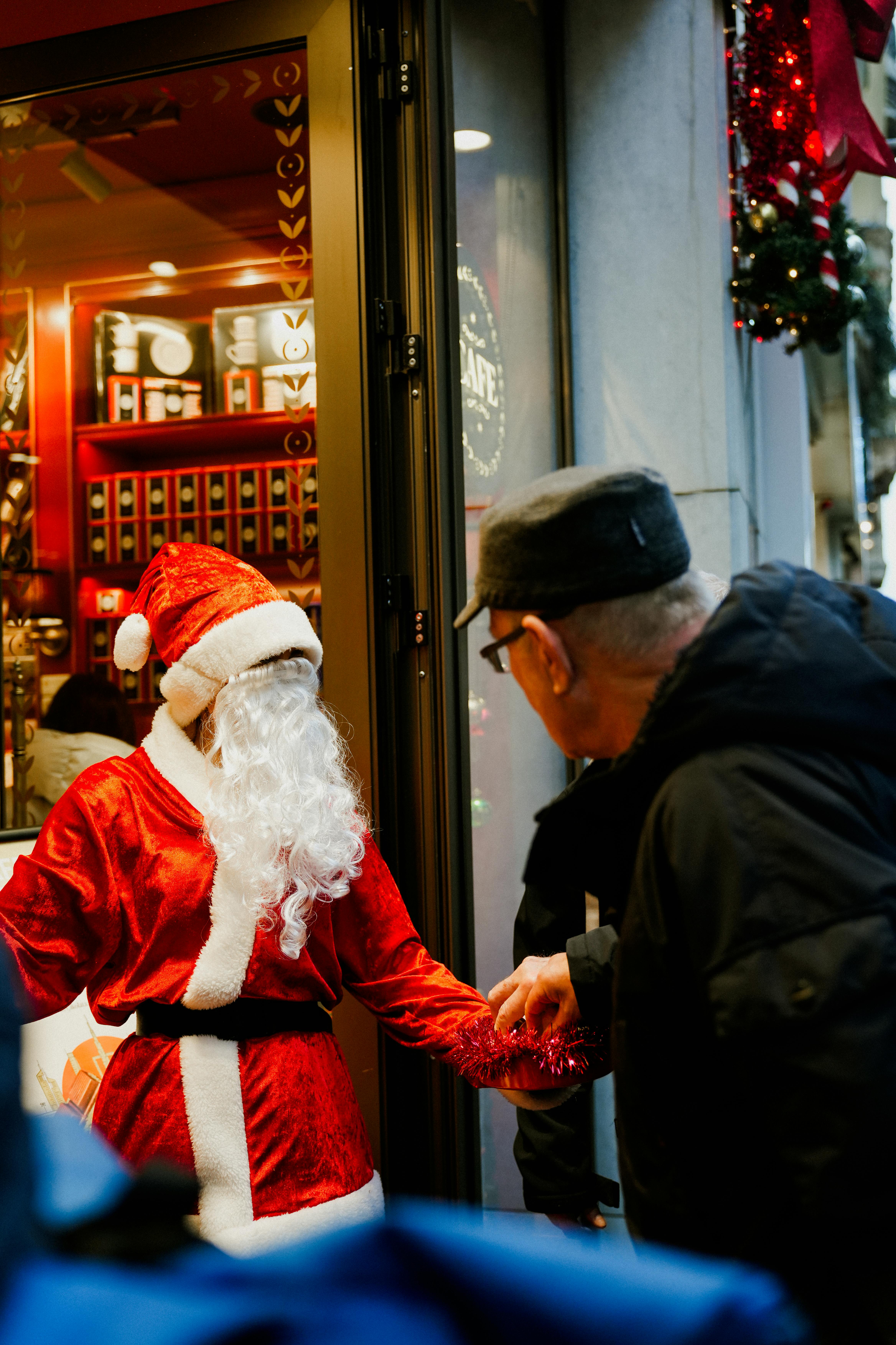Santa Claus interacting with passerby during Christmas · Free Stock Photo