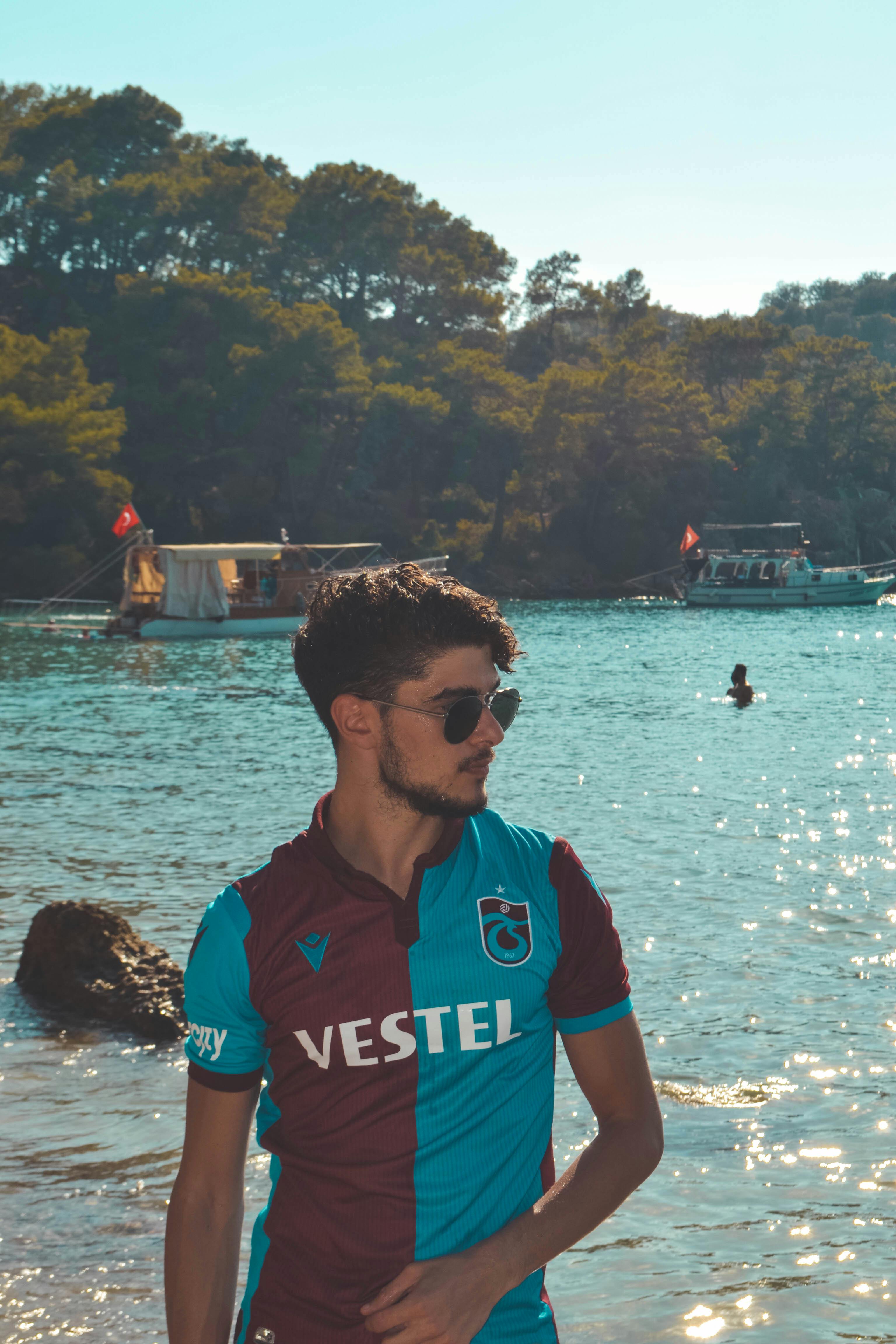 Young man by scenic waterfront in summer · Free Stock Photo