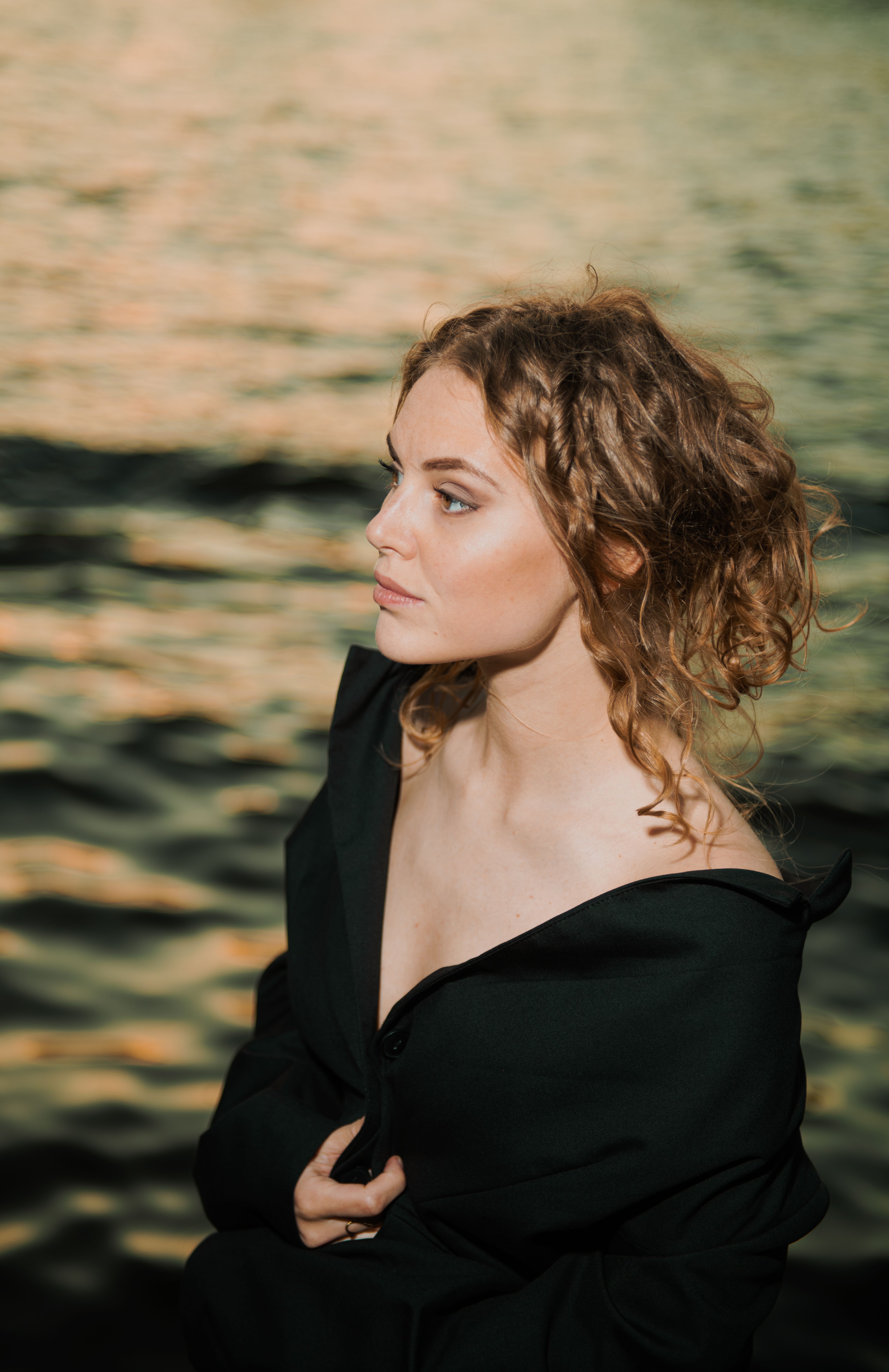 Serene Woman by Water at Sunset · Free Stock Photo