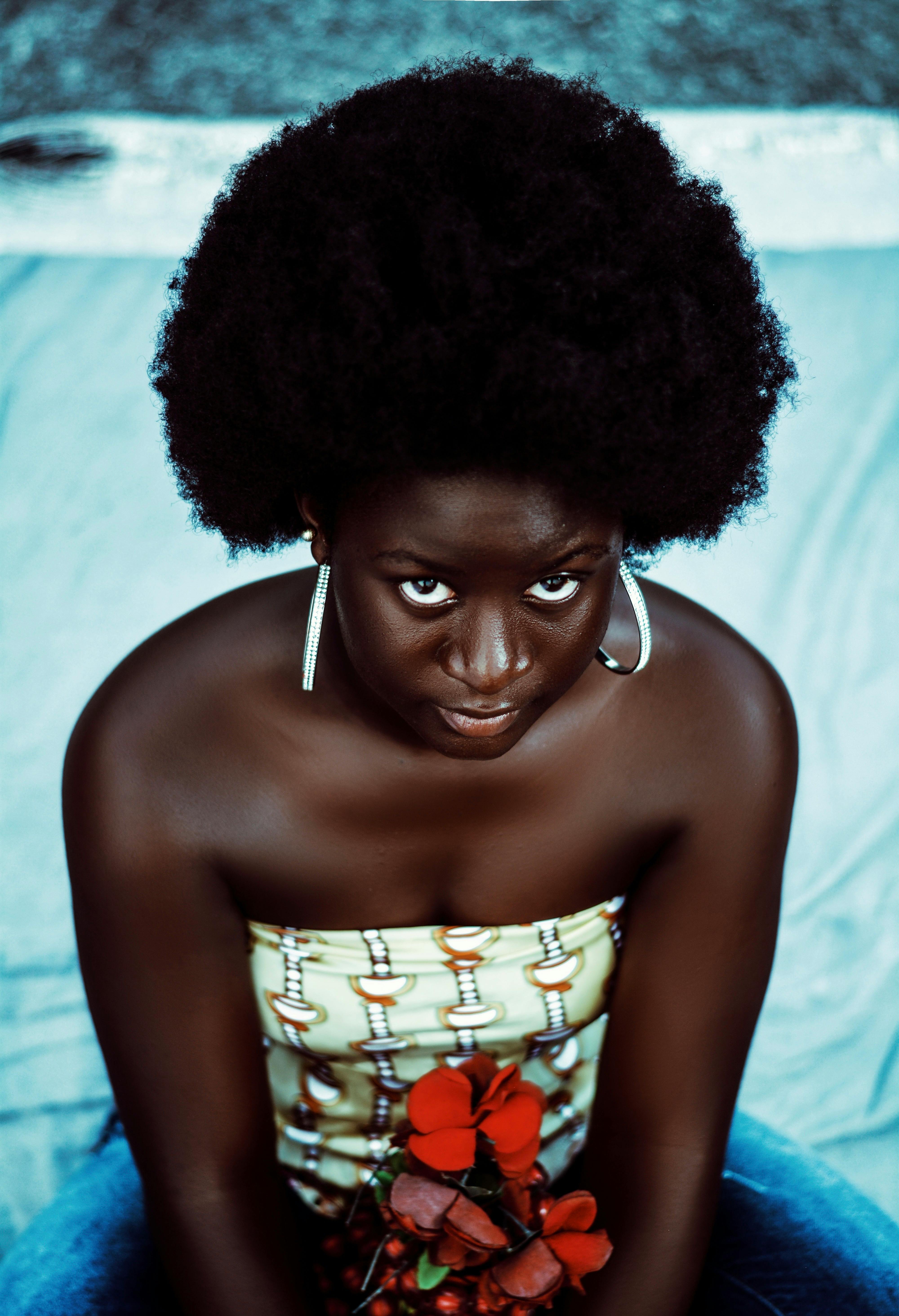 Femme Africaine élégante Avec Une Coupe Afro Et Des Roses Rouges ...