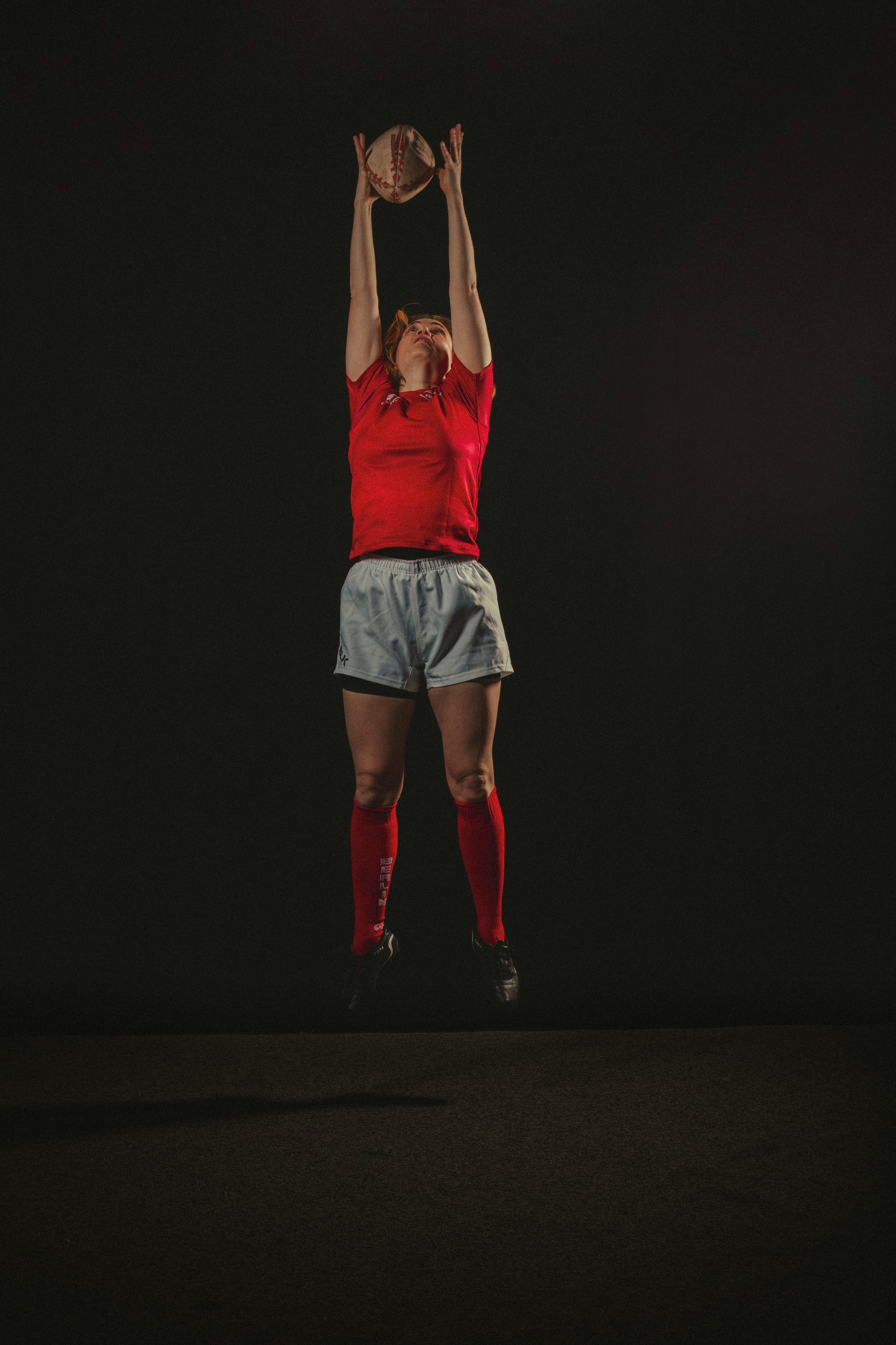 Dynamic Rugby Player Jumping to Catch Ball · Free Stock Photo