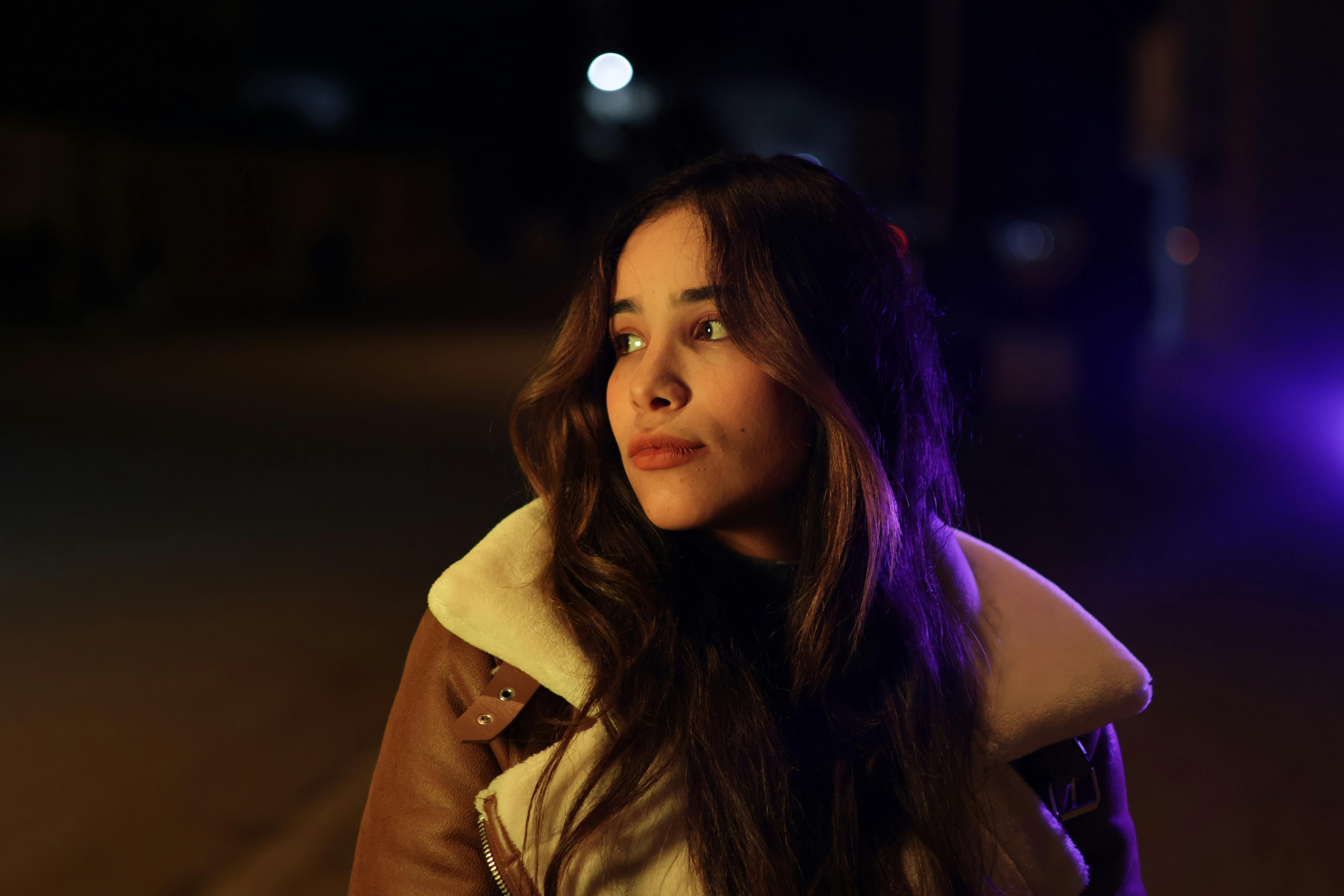 Thoughtful Woman Under Night Street Lights · Free Stock Photo