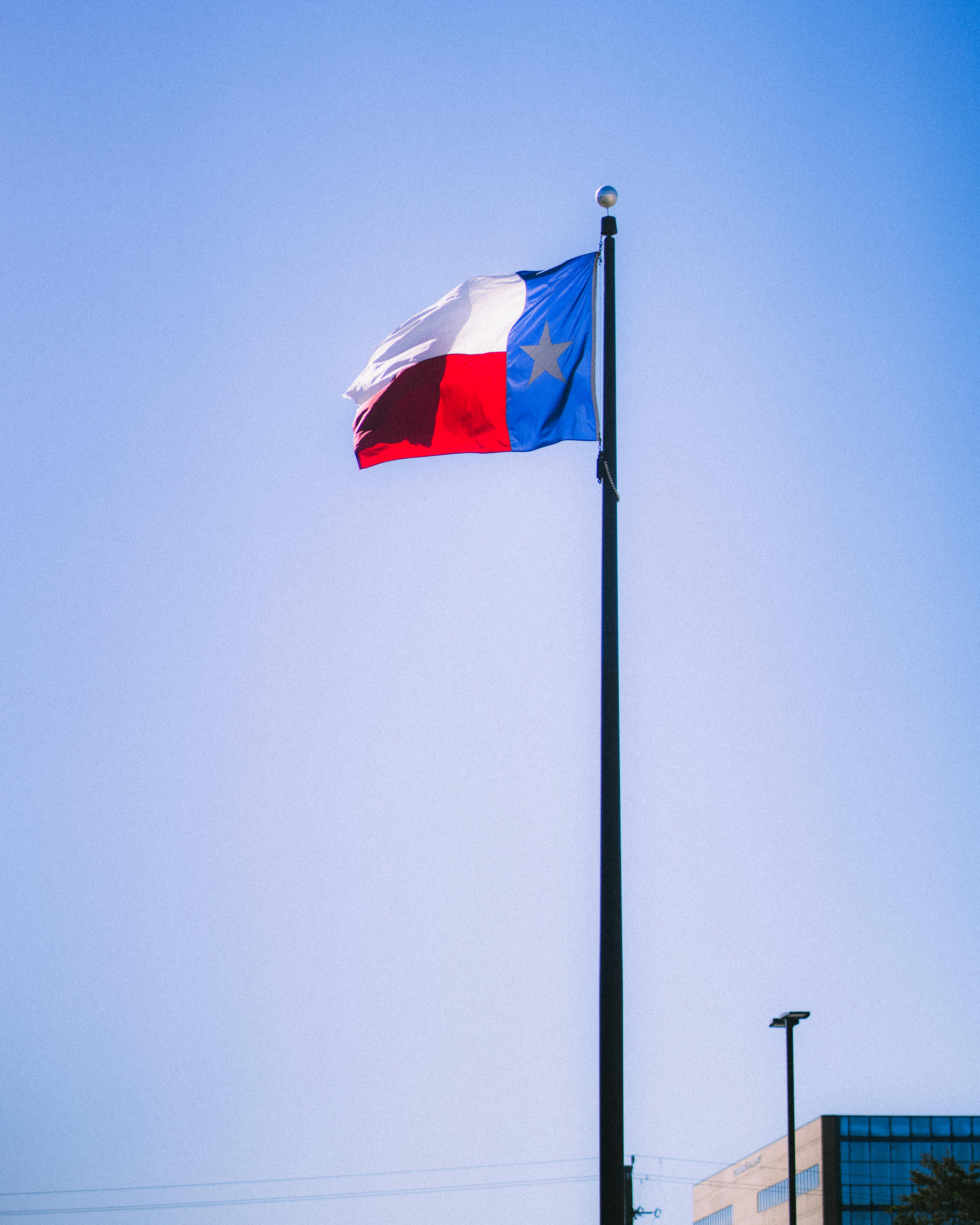 Texas Flag Waving on a Clear Day in Houston · Free Stock Photo