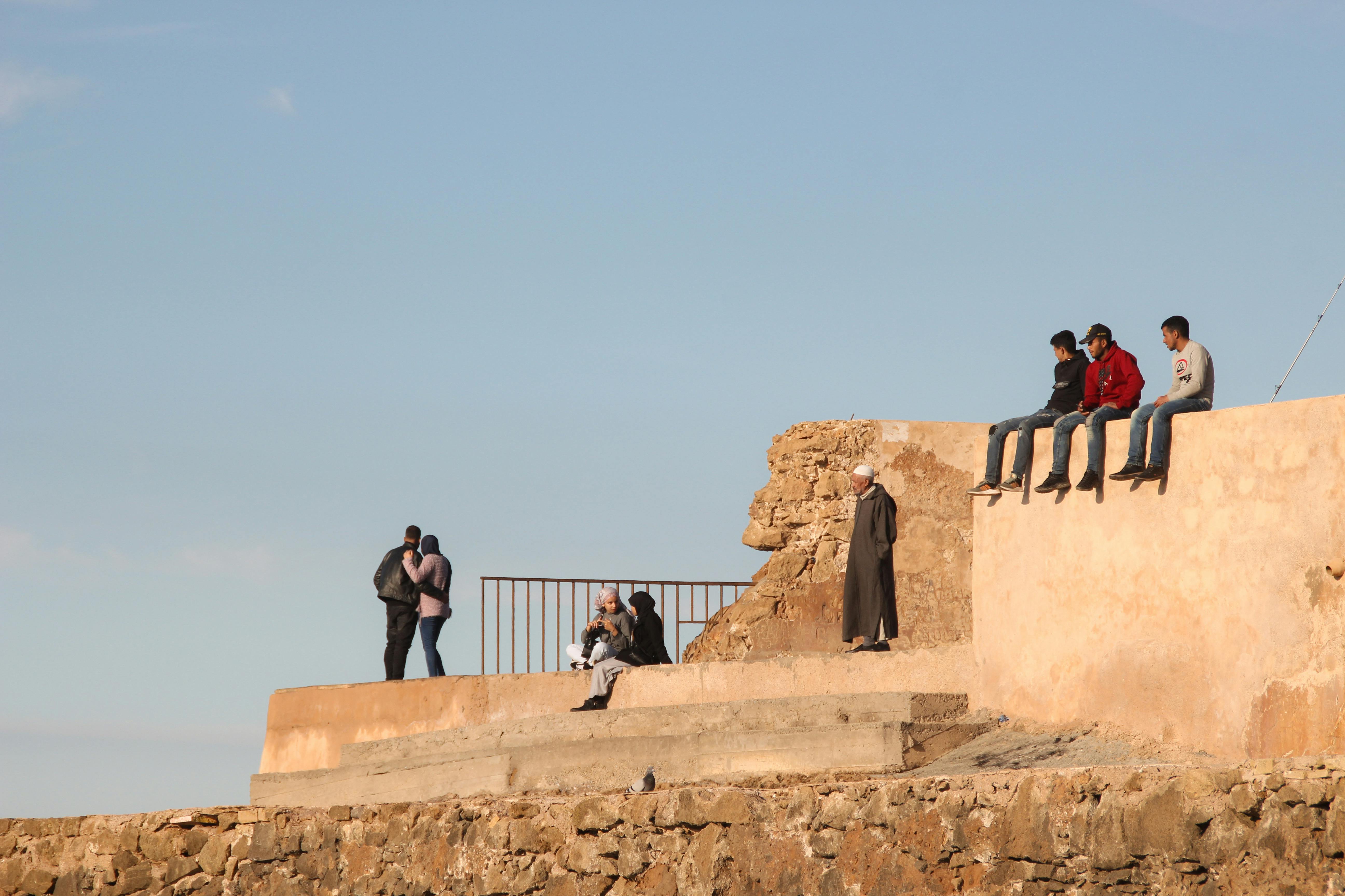 People Enjoying Sunny Day on Moroccan Fort Wall · Free Stock Photo