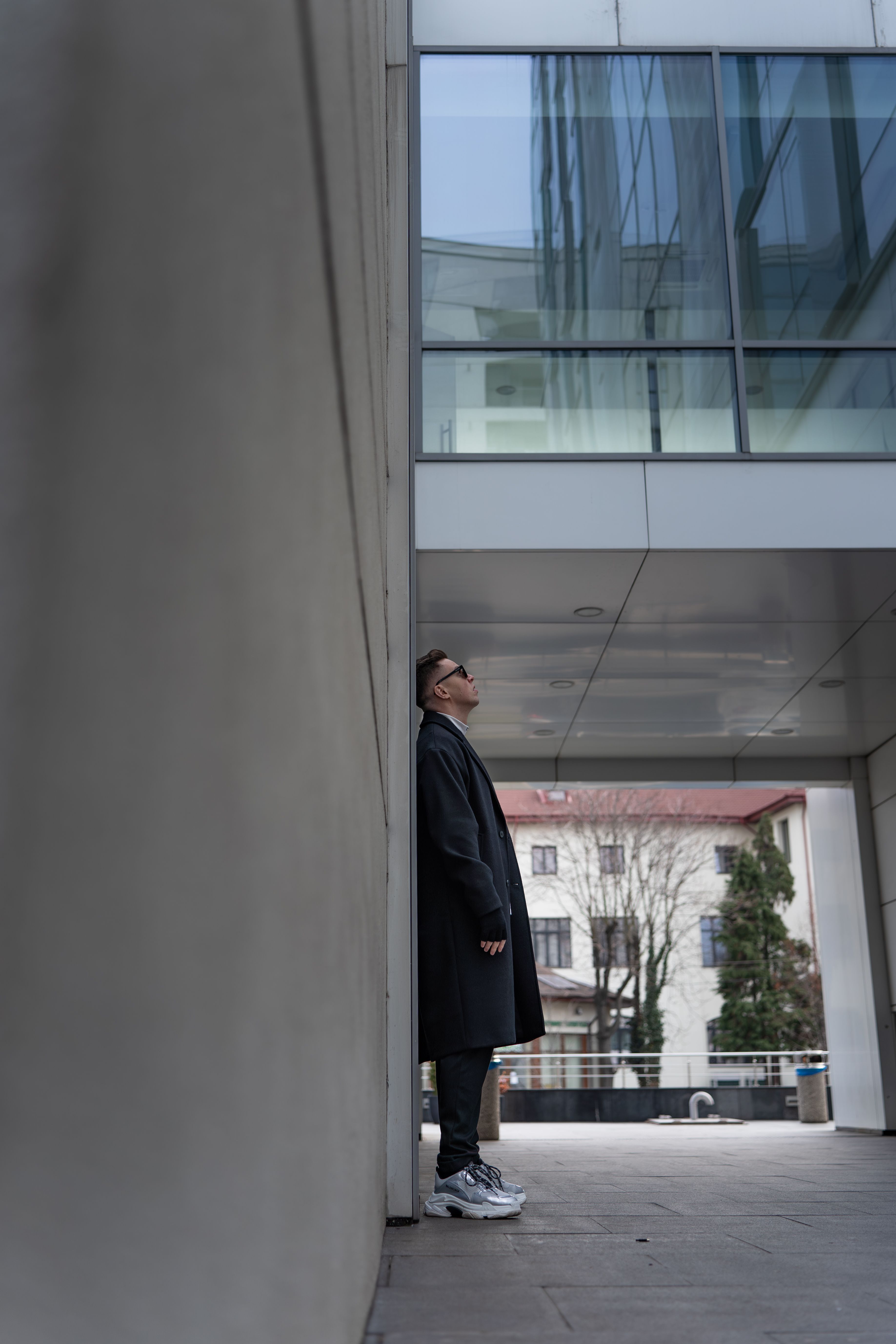 Urban Contemplation: Man in Modern Building Corridor · Free Stock Photo