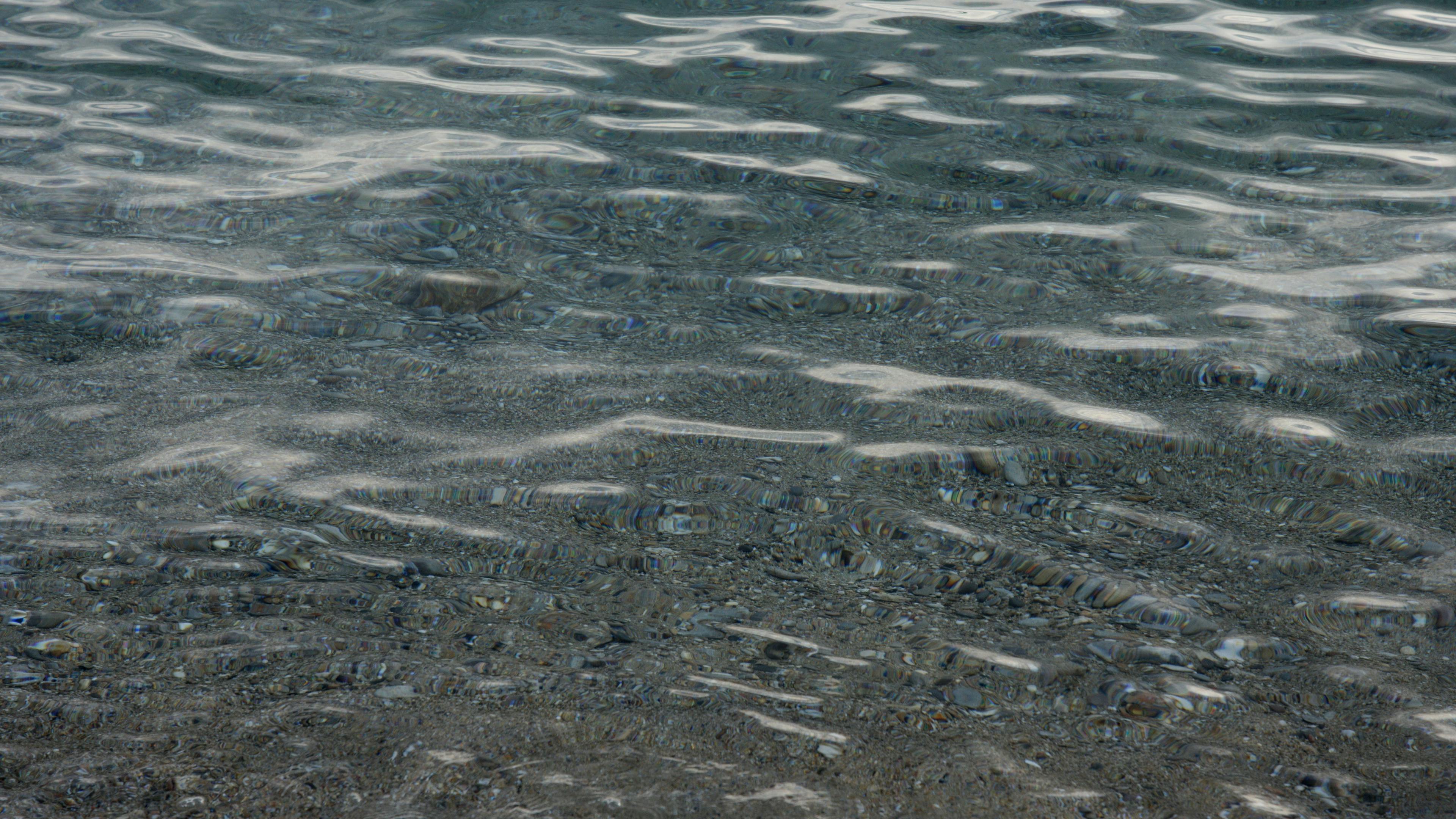 Serene Ocean Water Ripples at Pebble Beach · Free Stock Photo