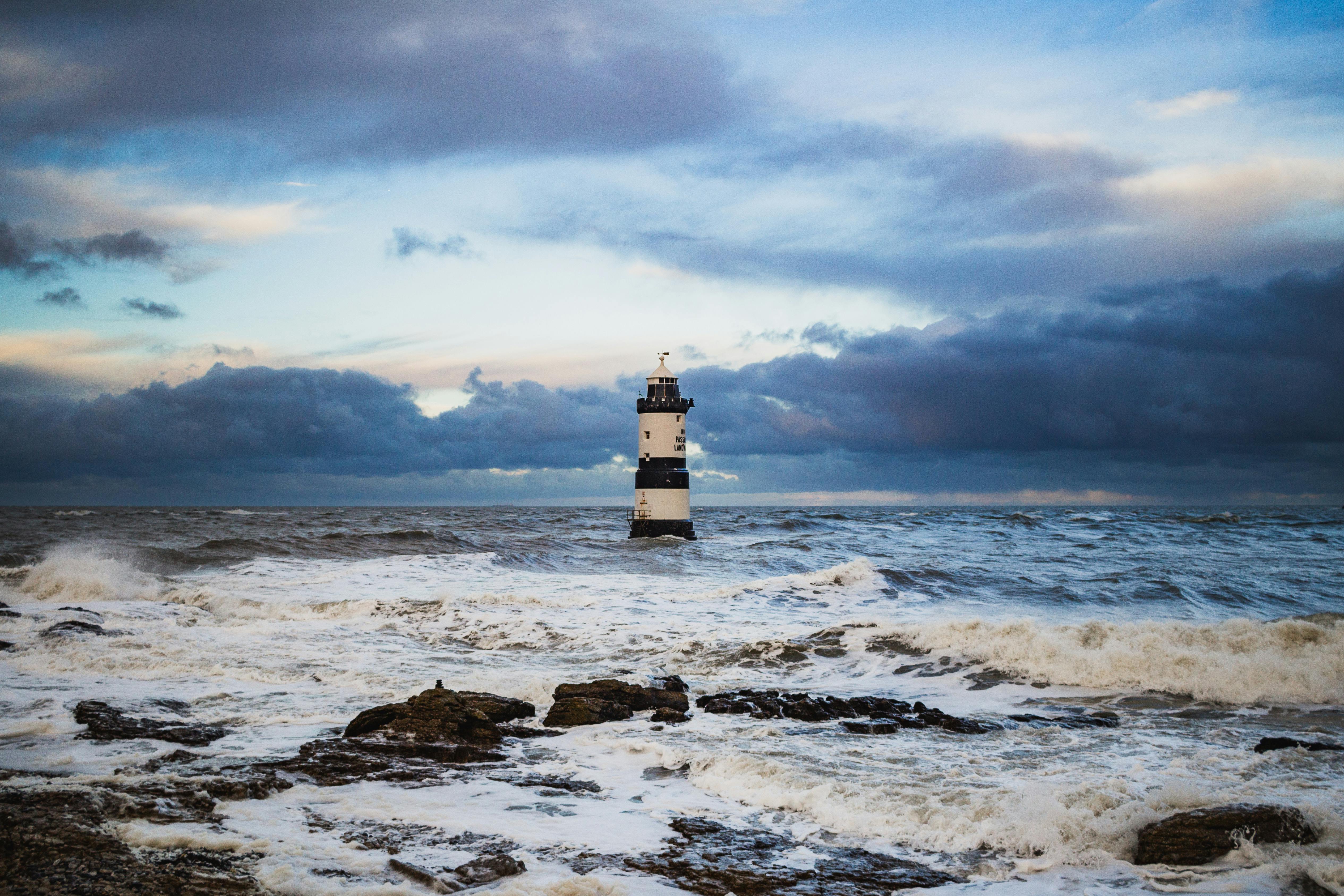 Dramatic Lighthouse on Rocky Ocean Coastline · Free Stock Photo