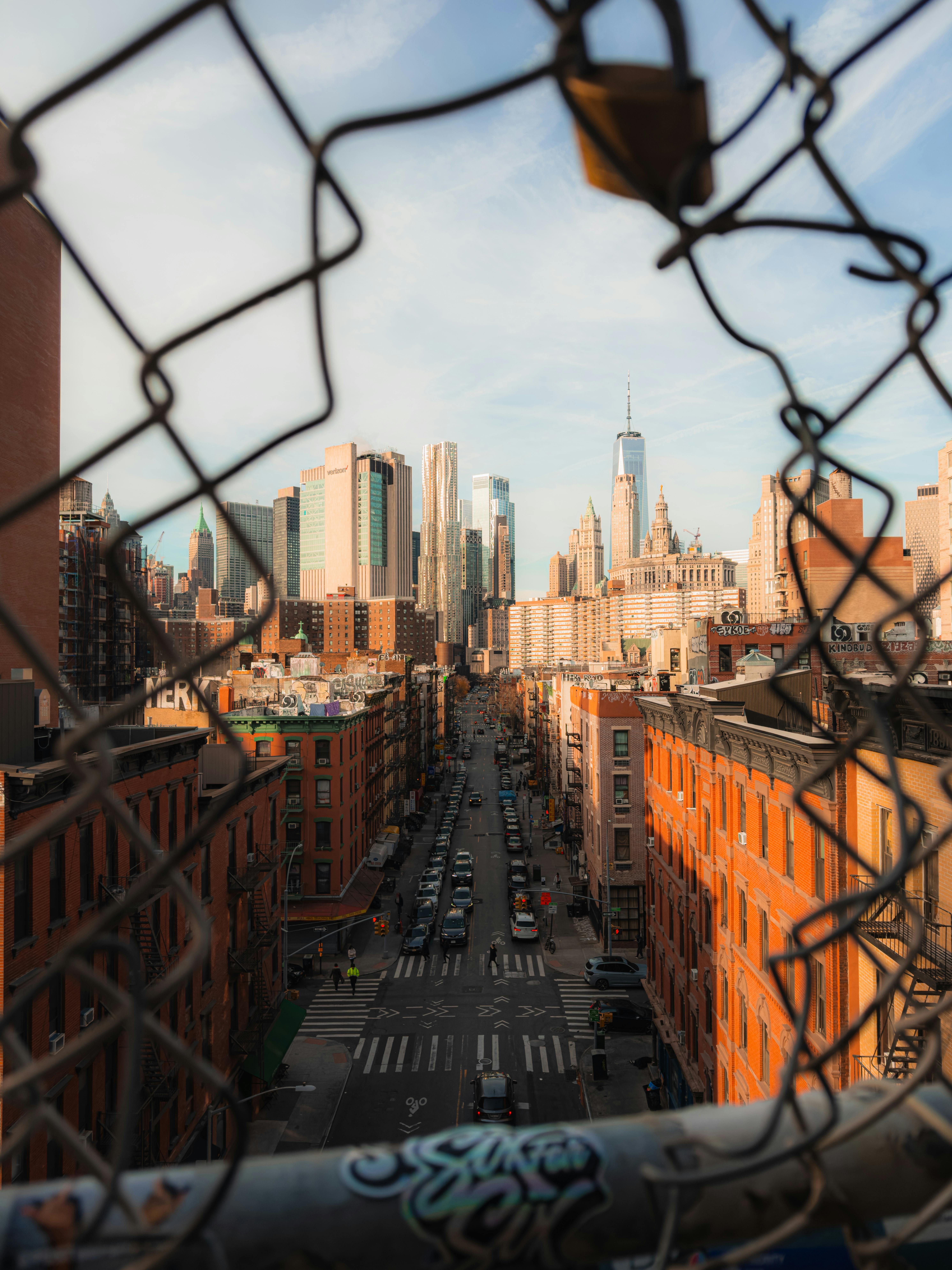 Urban Skyline through Chain Link Fence in Daylight · Free Stock Photo