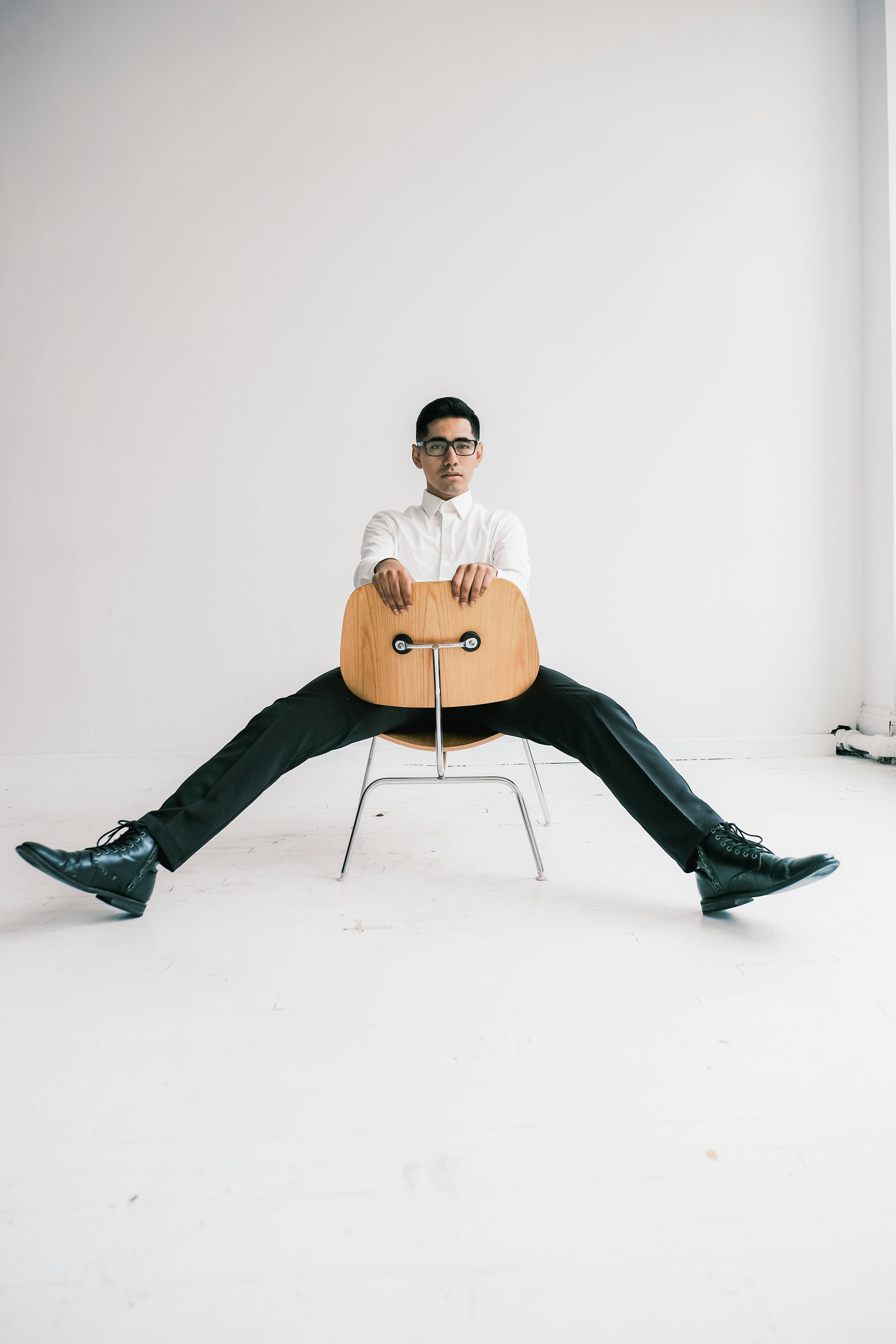 Minimalist Portrait of Man Sitting Backwards on Chair · Free Stock Photo