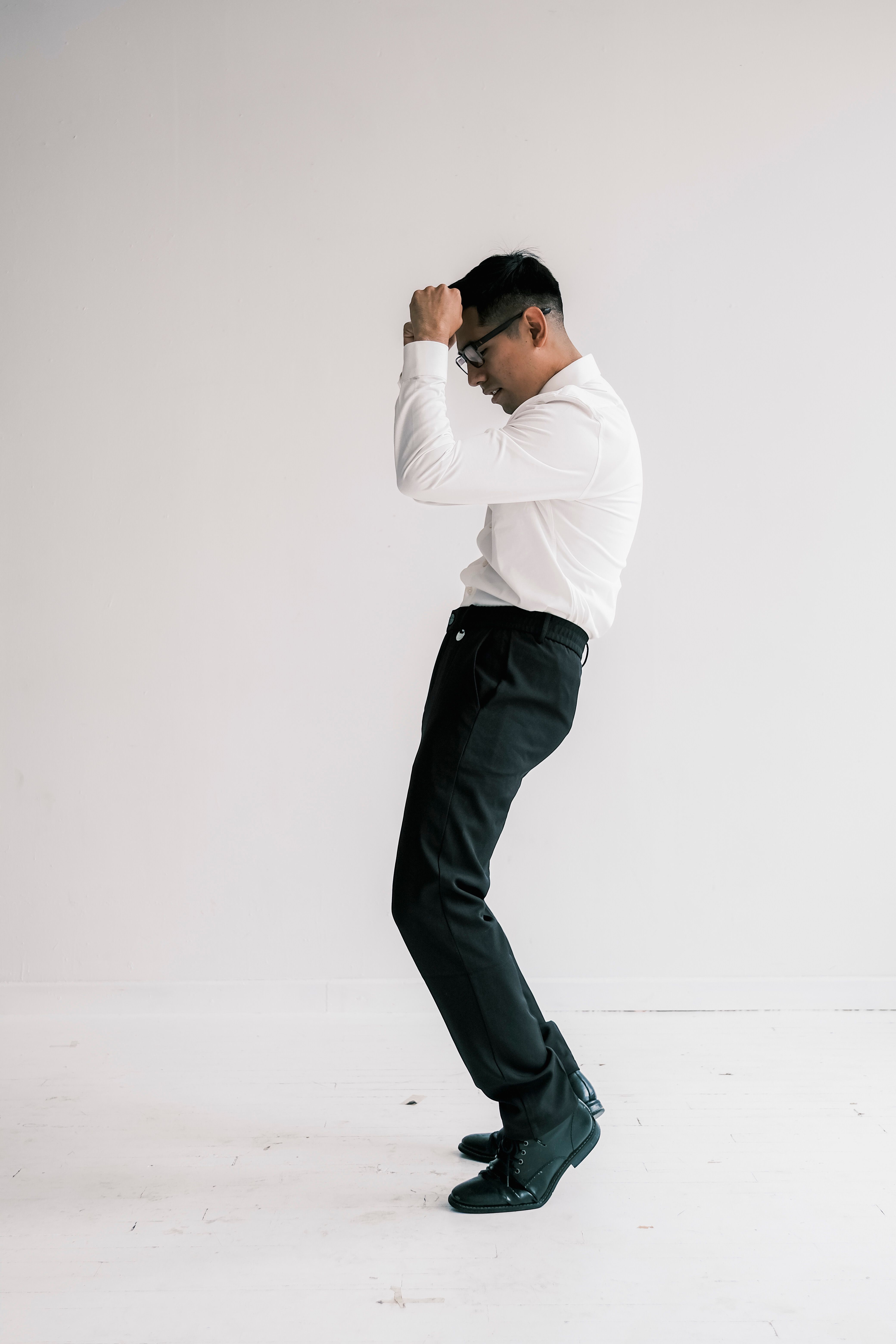 Person in Stylish Pose Against Minimalist Background · Free Stock Photo