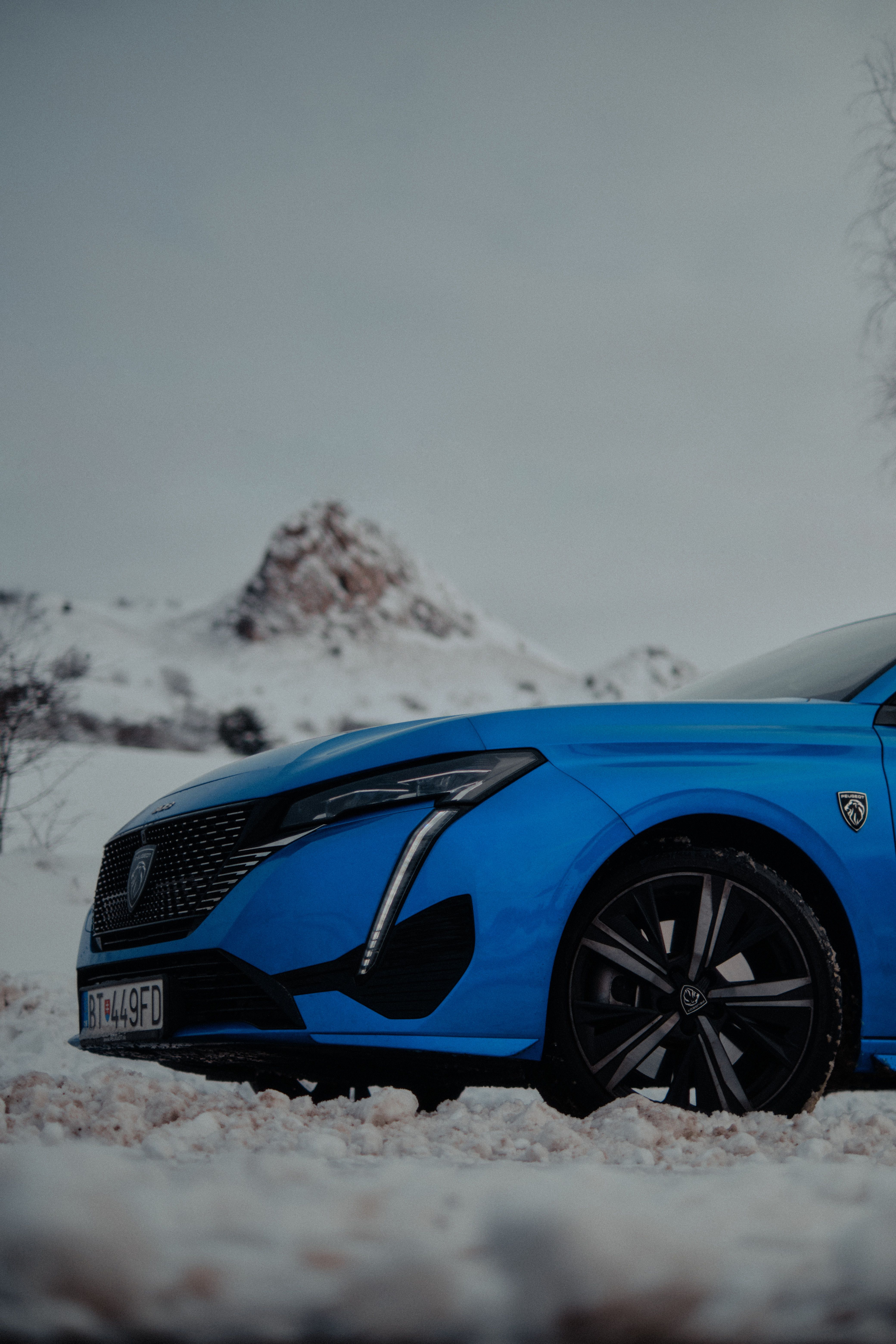 Sleek Blue Car in Snowy Mountain Landscape · Free Stock Photo