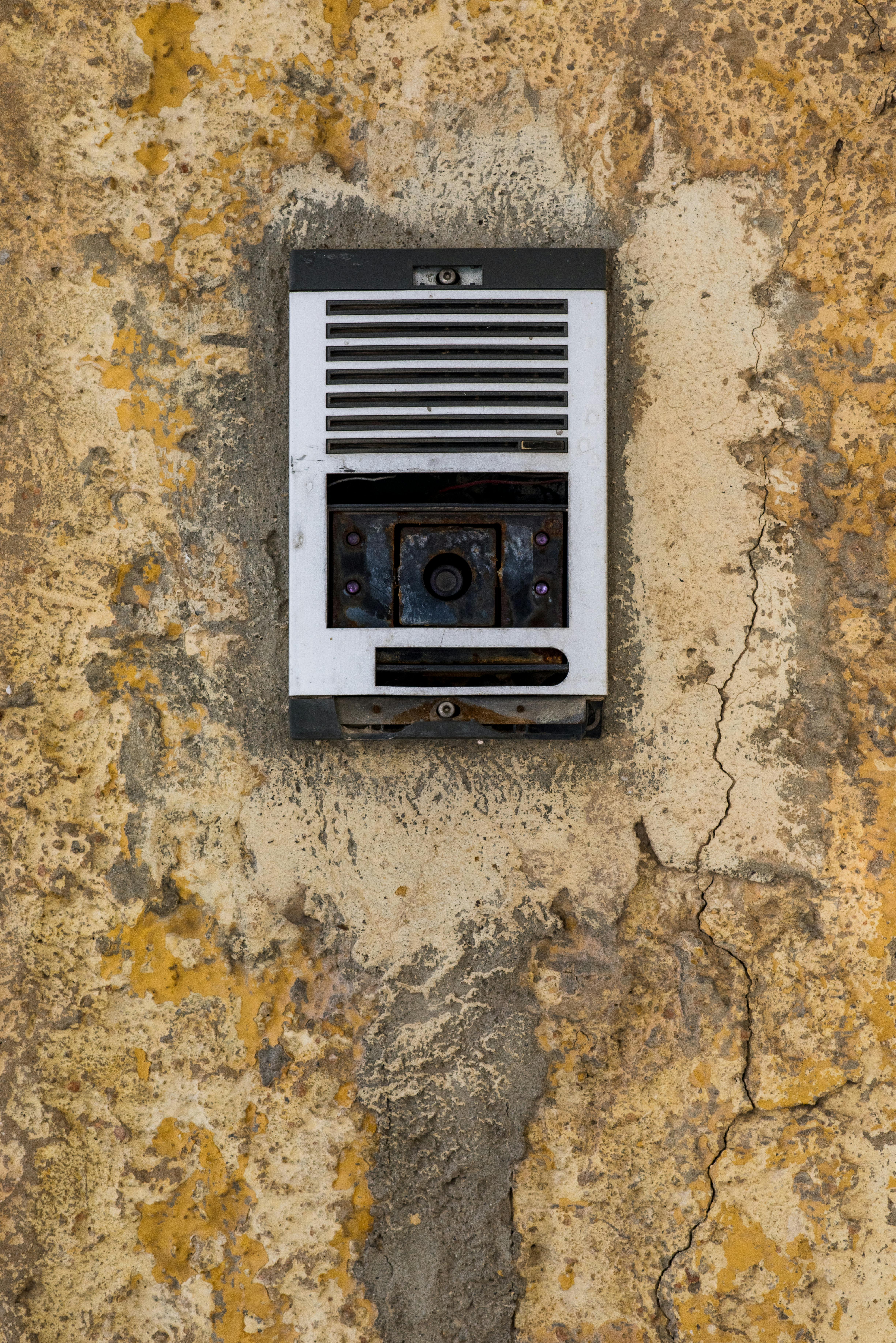 Rusty Intercom on Weathered Wall Outdoors · Free Stock Photo