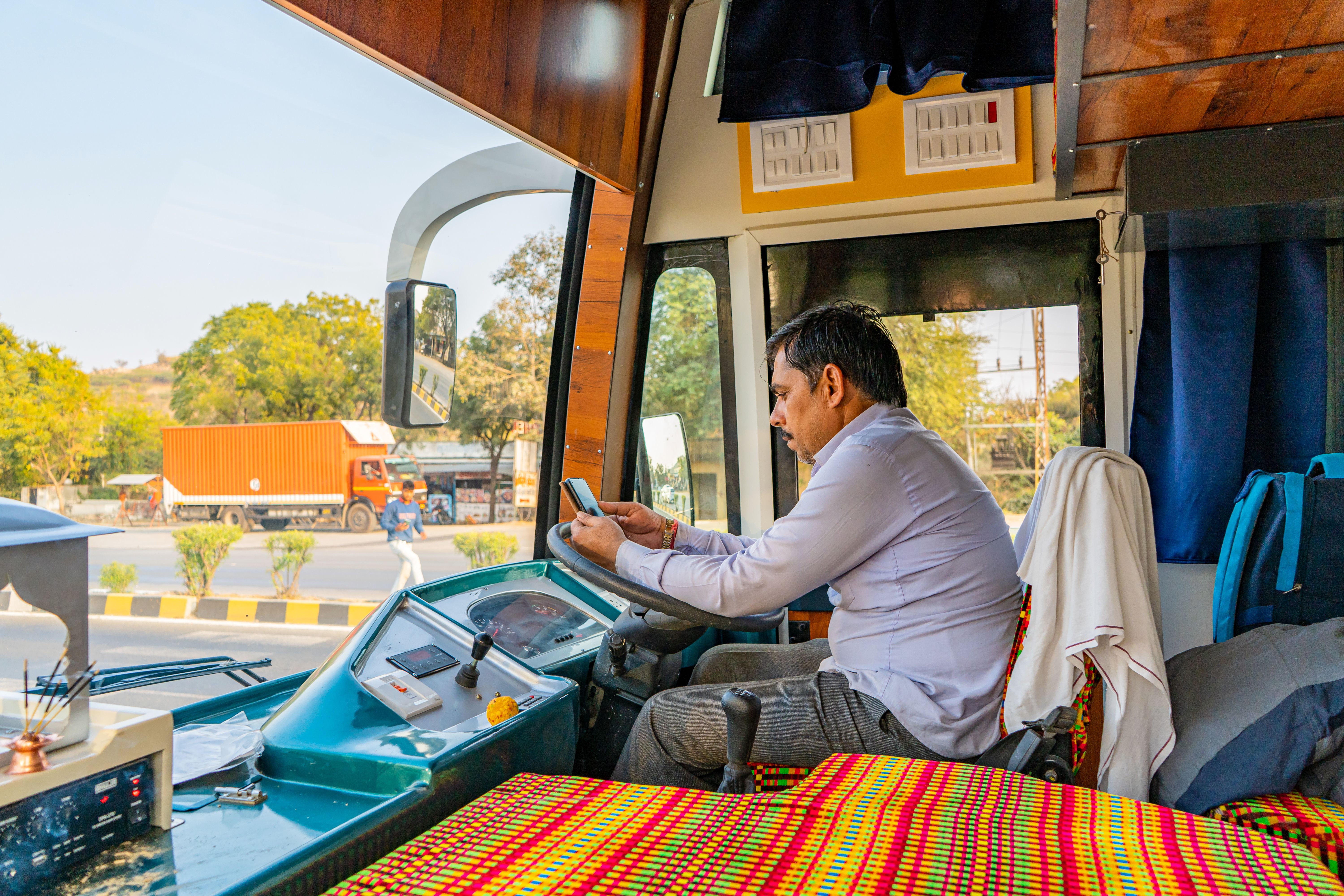Bus Driver Checking Phone in City Traffic · Free Stock Photo