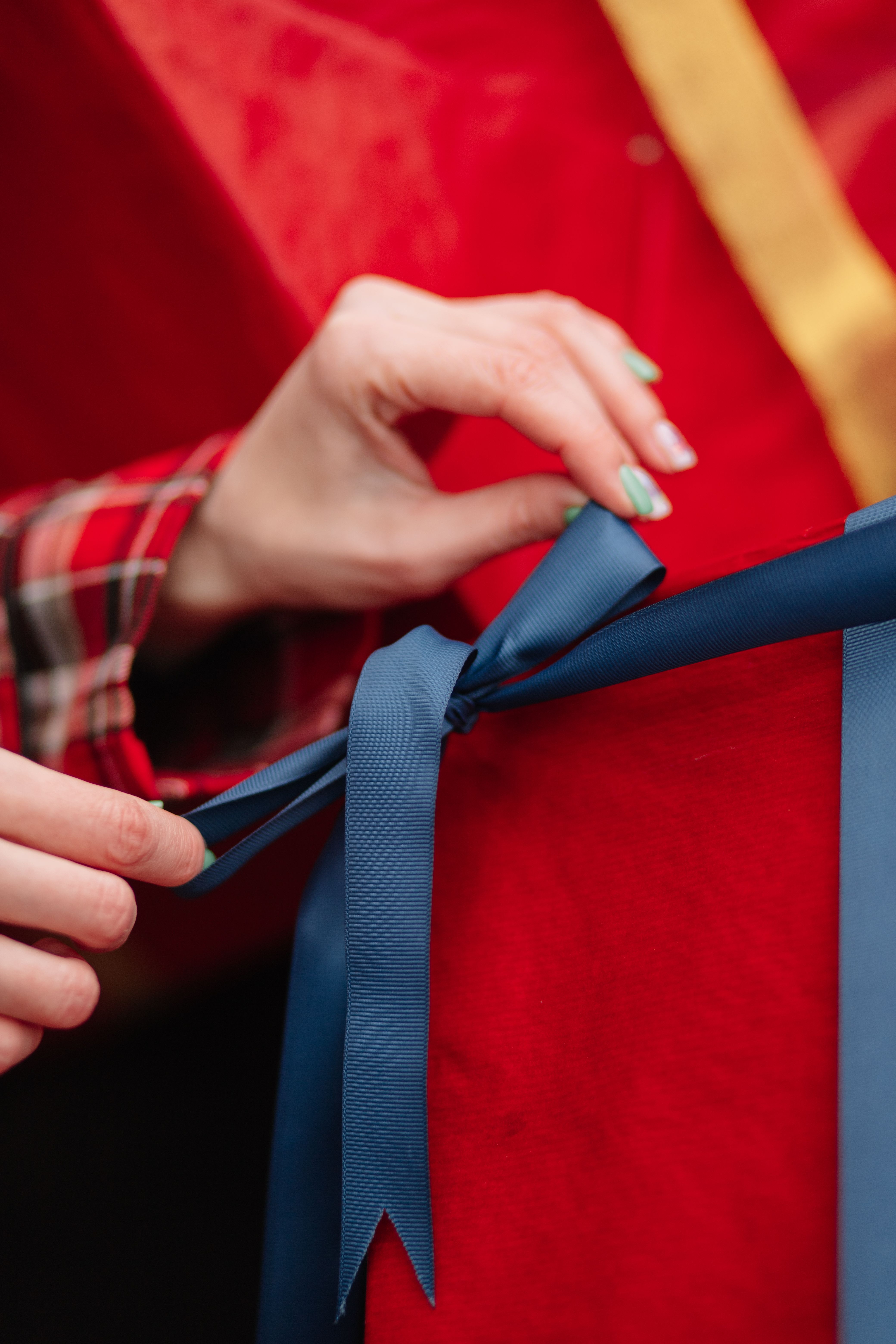Close-up of Hands Tying Blue Ribbon on Red Gift Box · Free Stock Photo