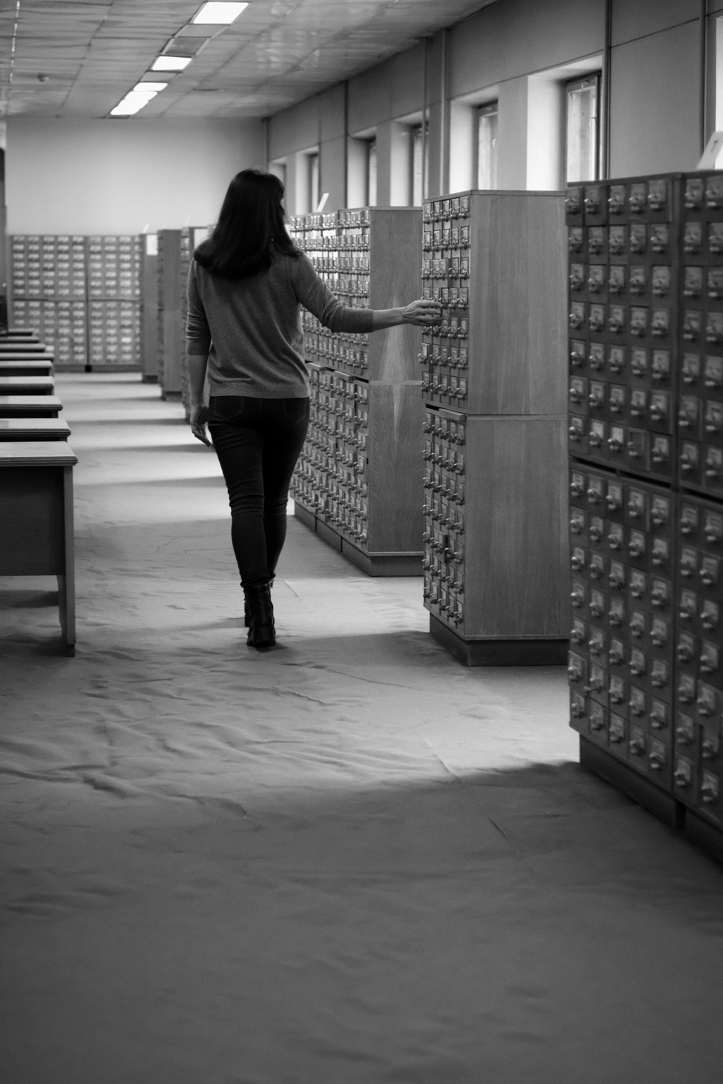 Woman Walking in Vintage Library Card Catalog Room · Free Stock Photo