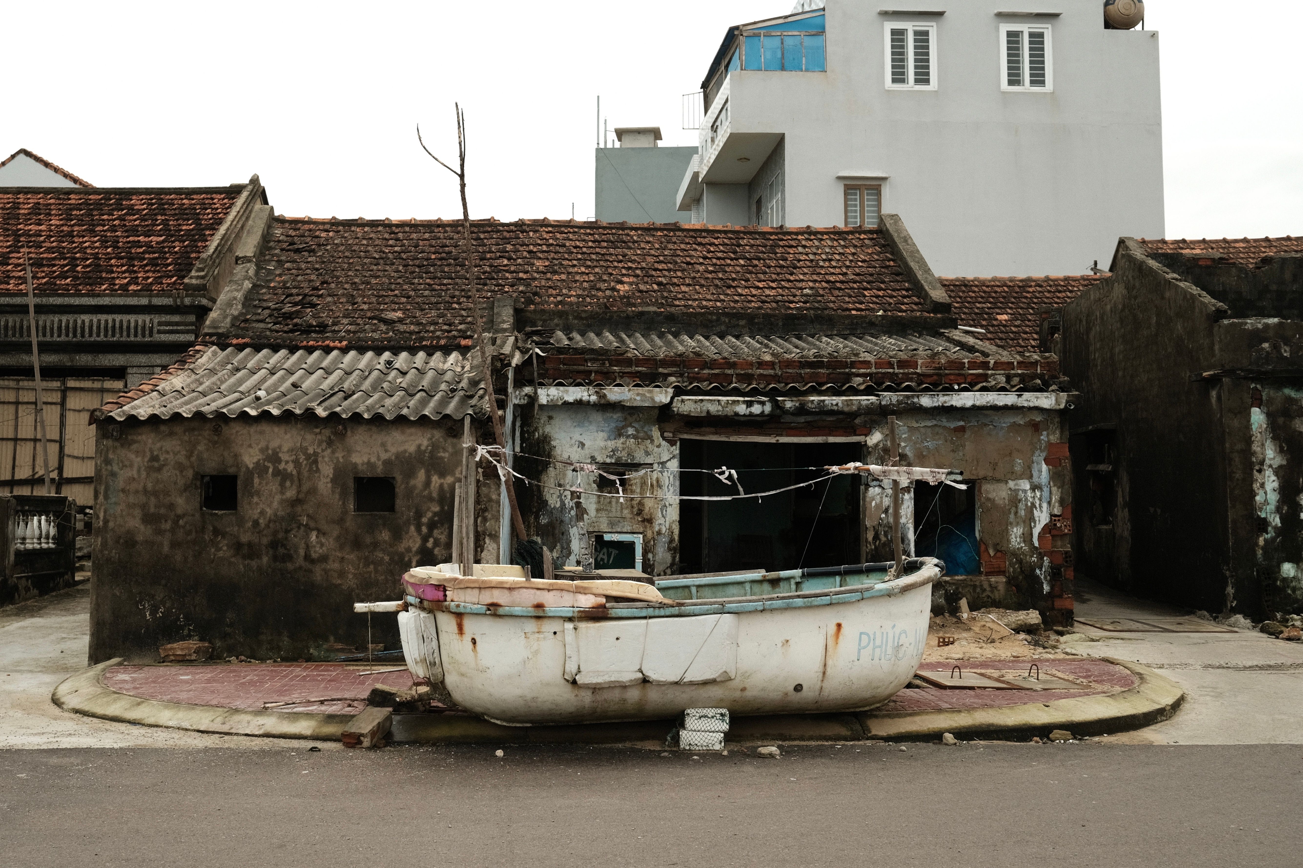 Rustic Village Scene with Old Boat and Weathered House · Free Stock Photo