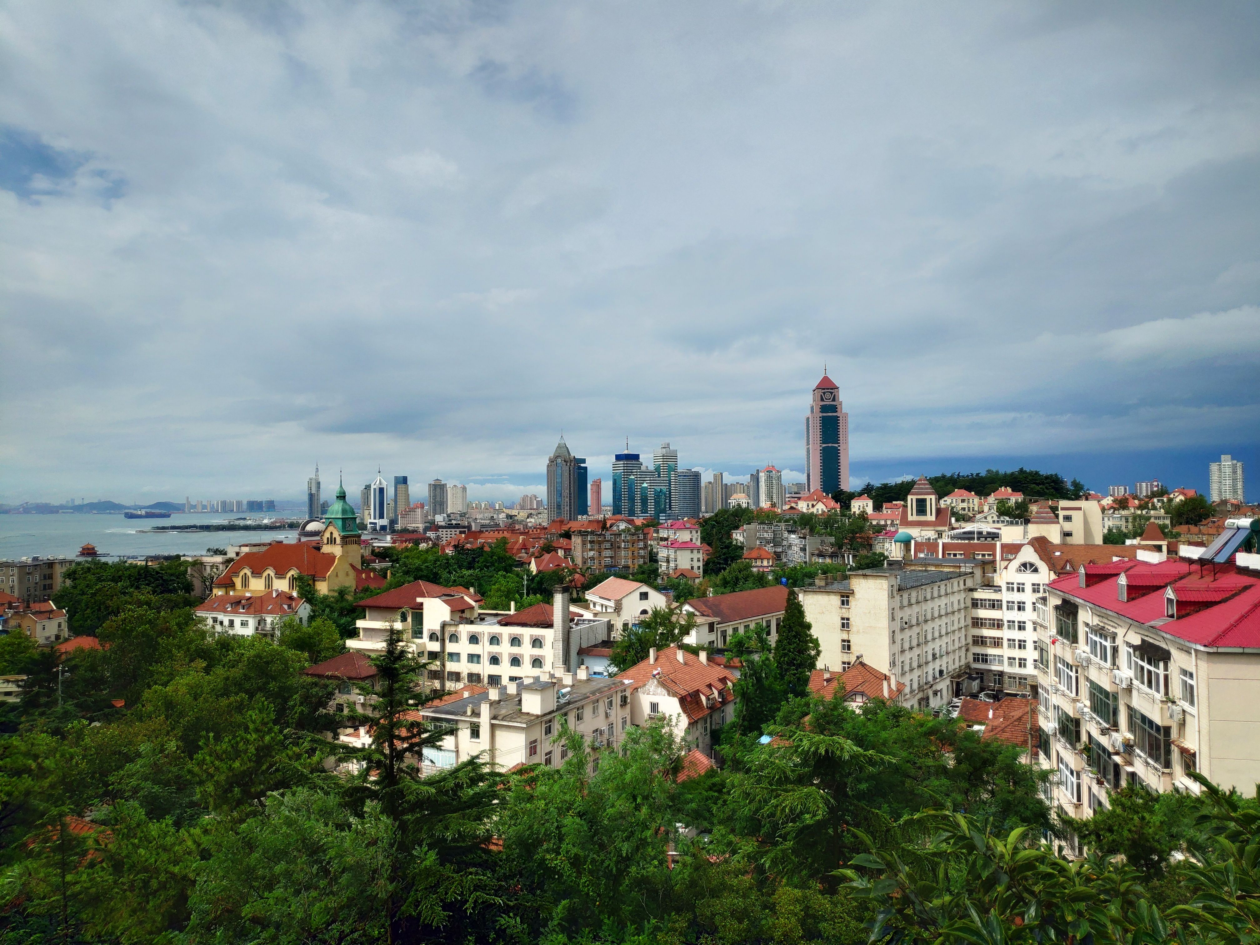 Skyline View of Qingdao Cityscape Under Cloudy Skies · Free Stock Photo