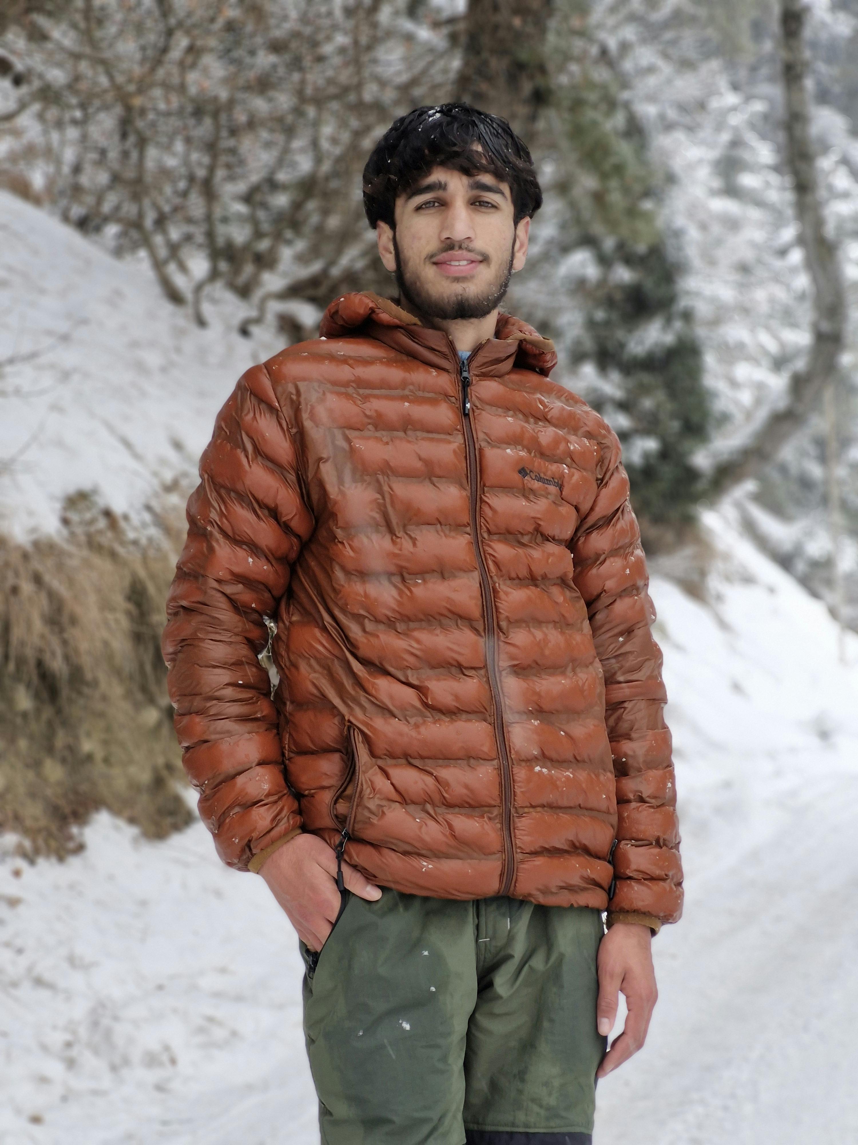 Young man in winter coat outdoors in snow · Free Stock Photo