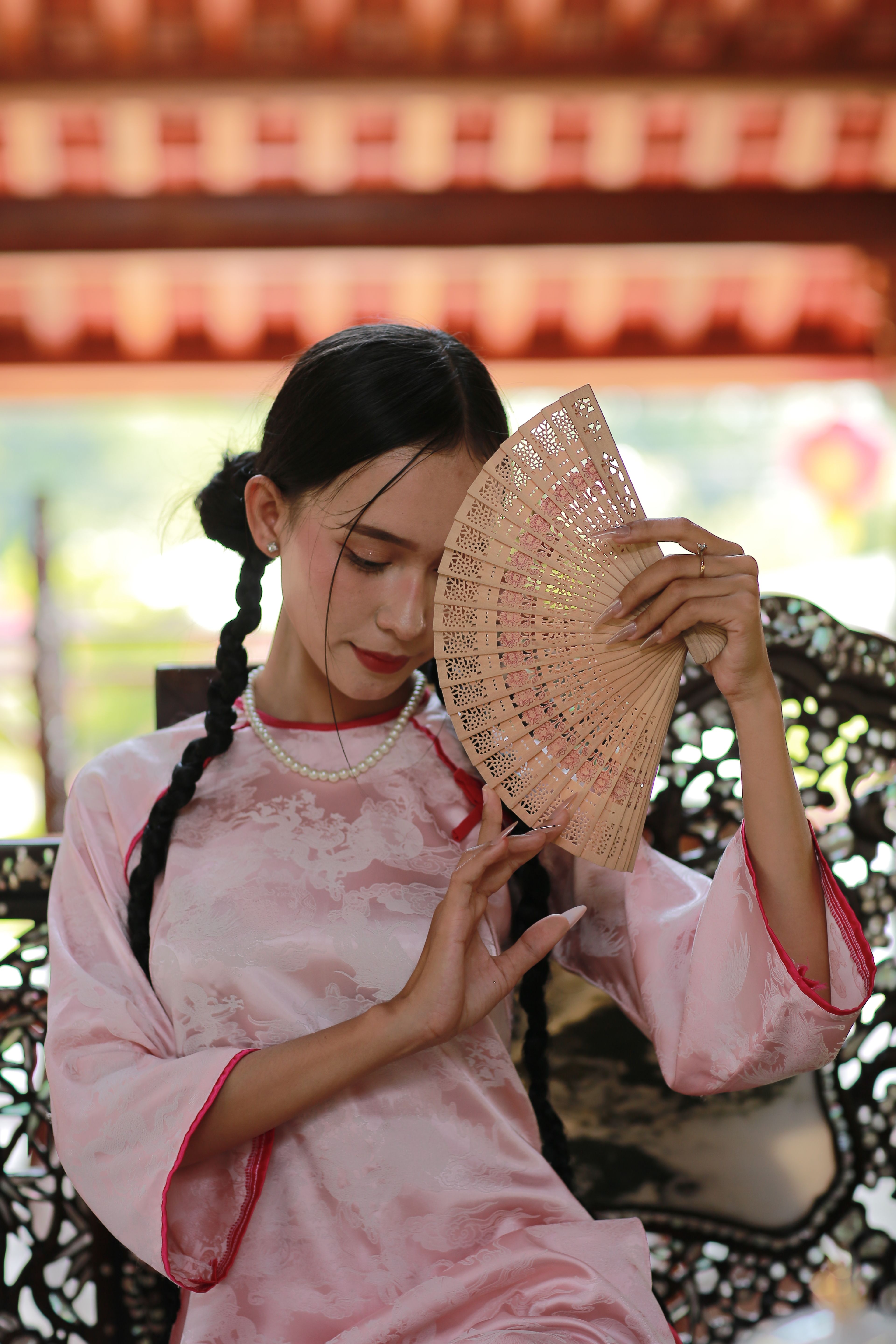 Elegant Woman in Pink Cheongsam with Fan · Free Stock Photo