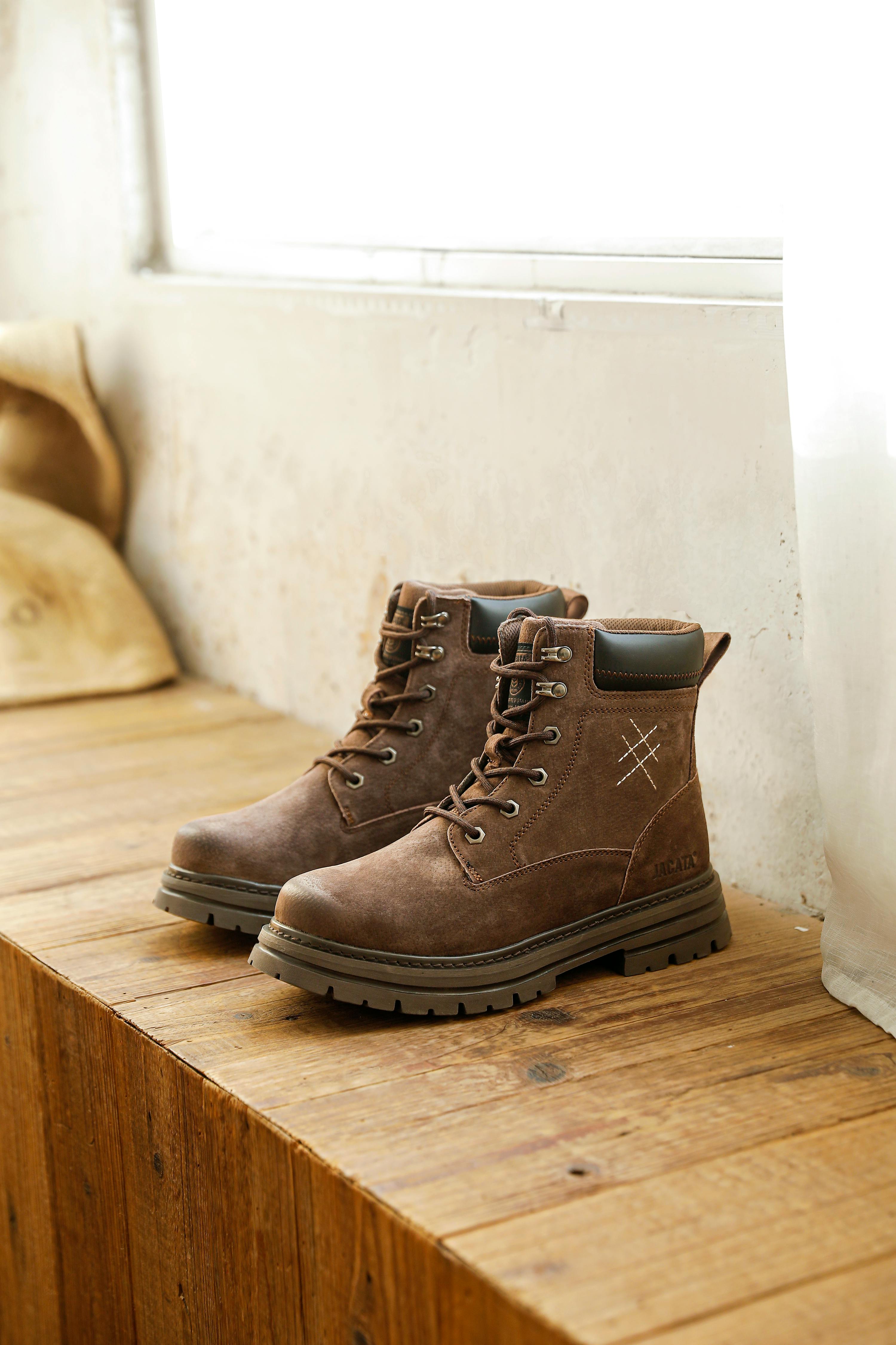 Sepatu Bot Kulit Coklat Bergaya Di Permukaan Kayu · Foto Stok Gratis