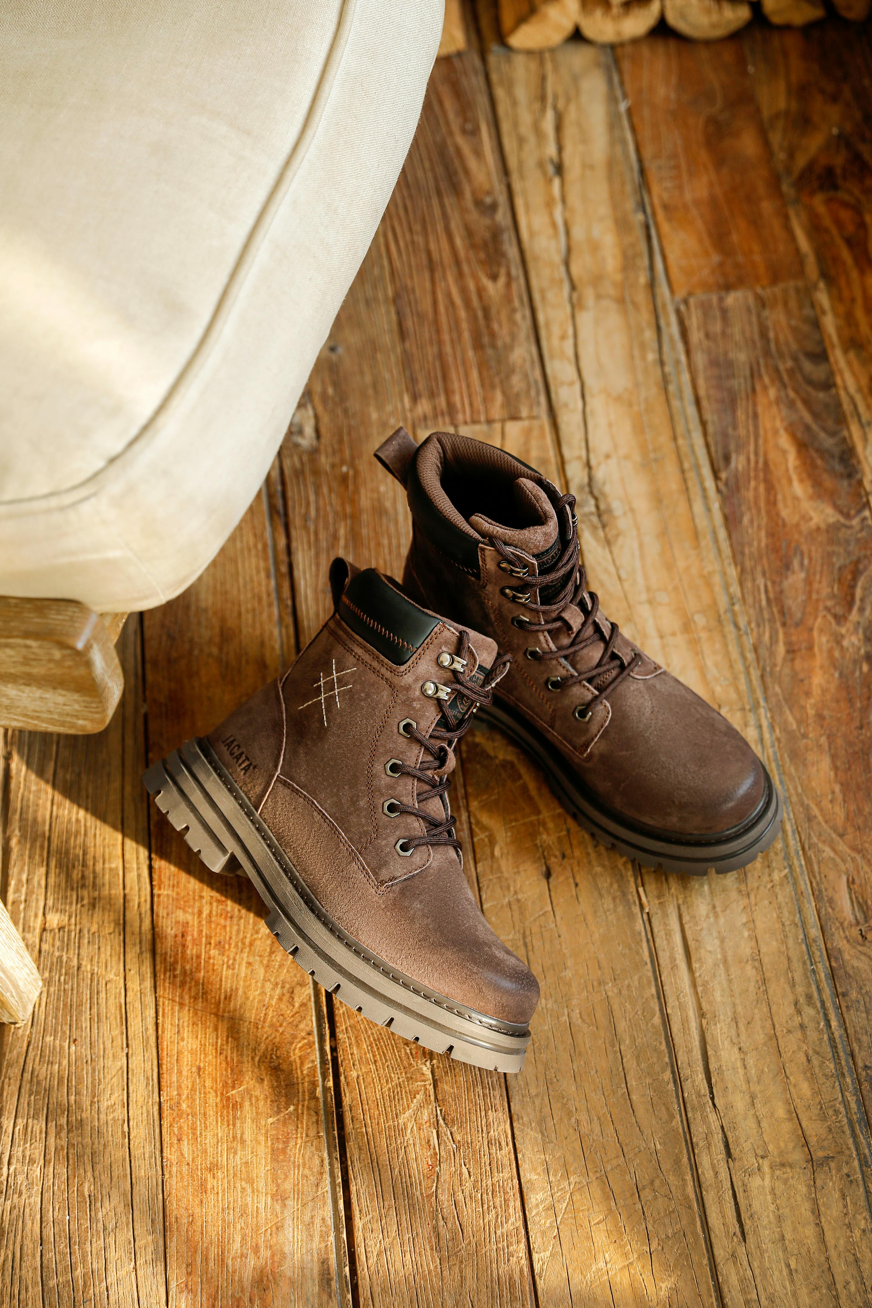 Brown leather boots on rustic wooden floor · Free Stock Photo