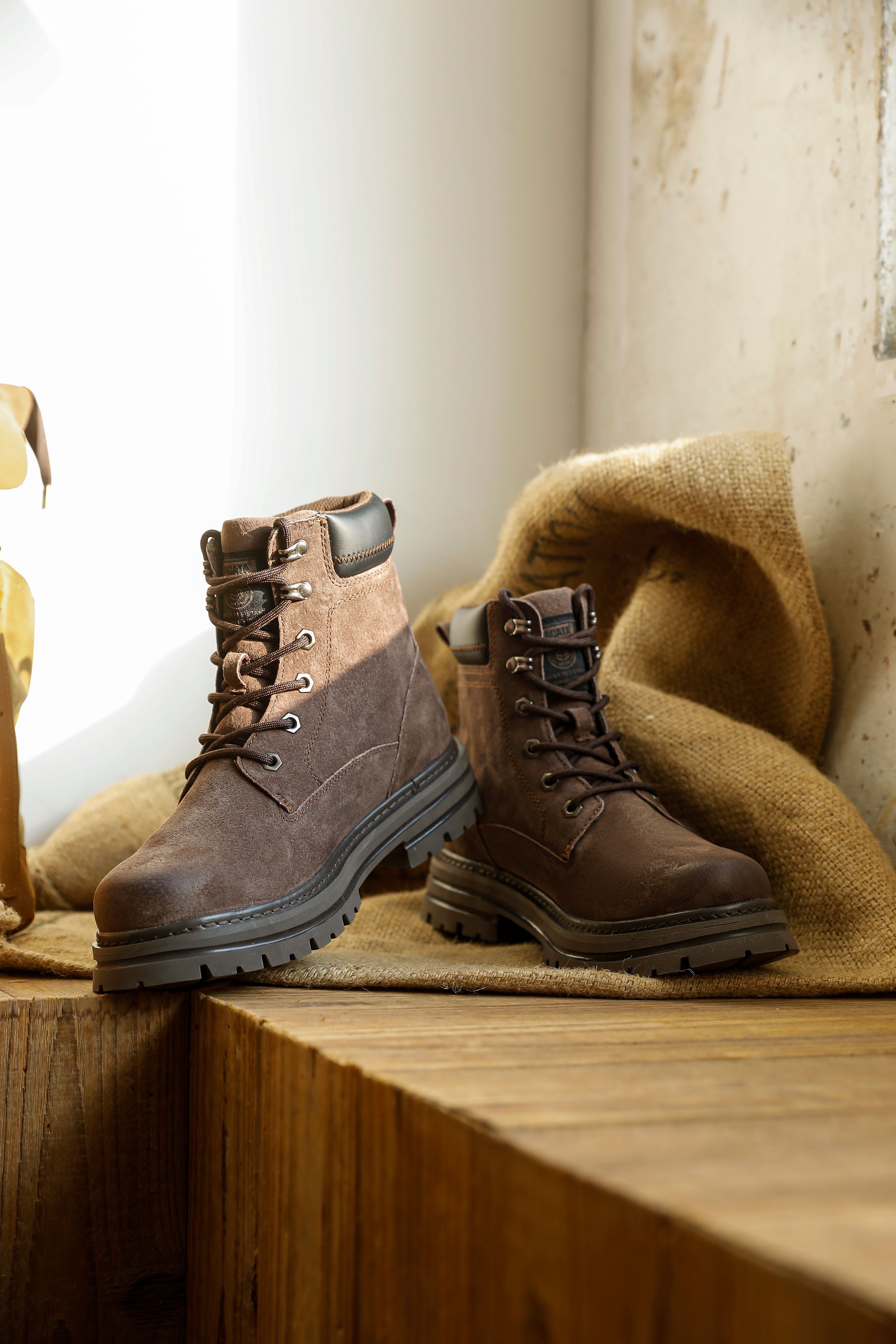 Rugged Leather Boots on Wooden Surface · Free Stock Photo
