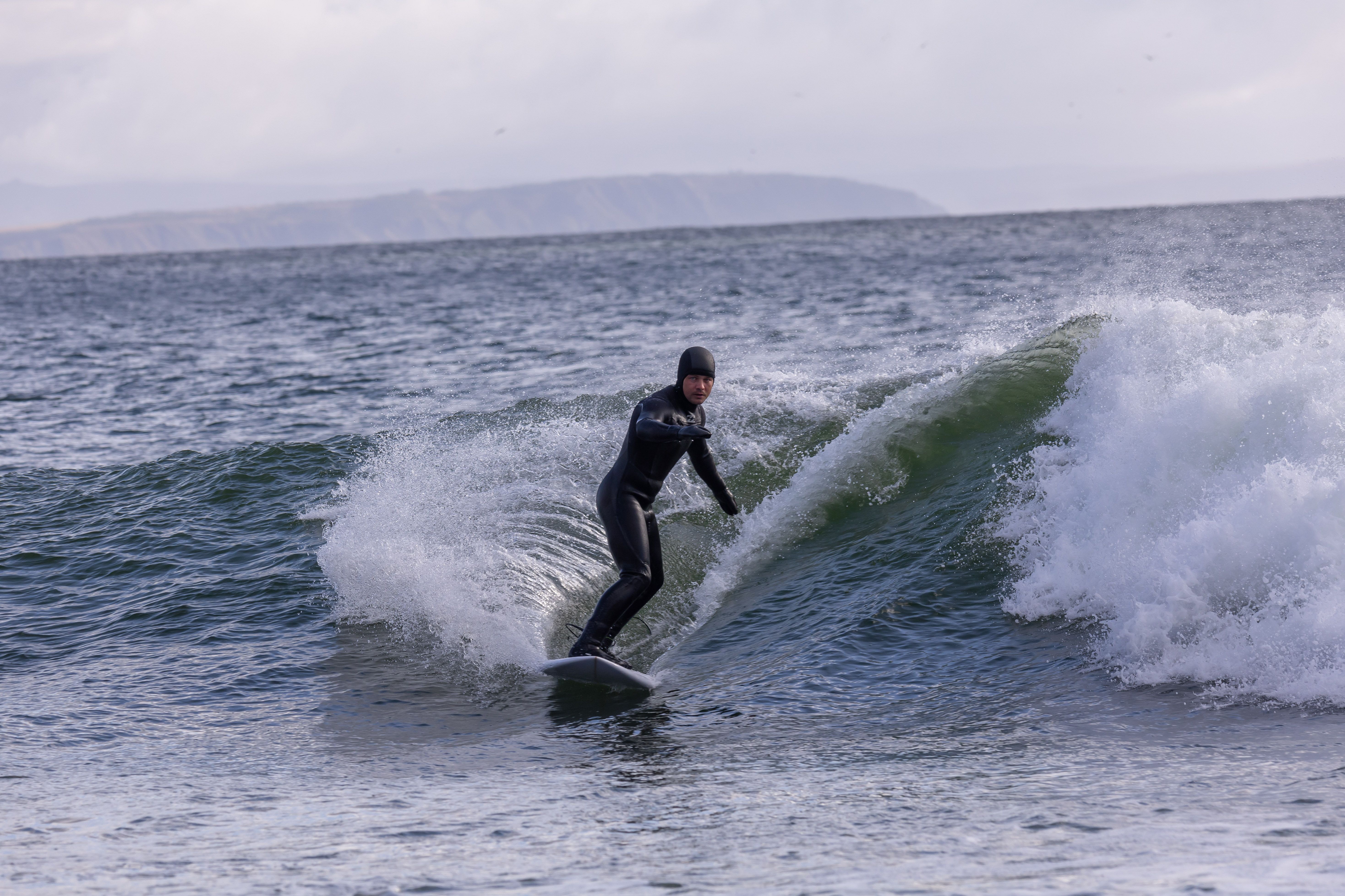 Surfer Riding Wave in Cold Ocean Waters · Free Stock Photo