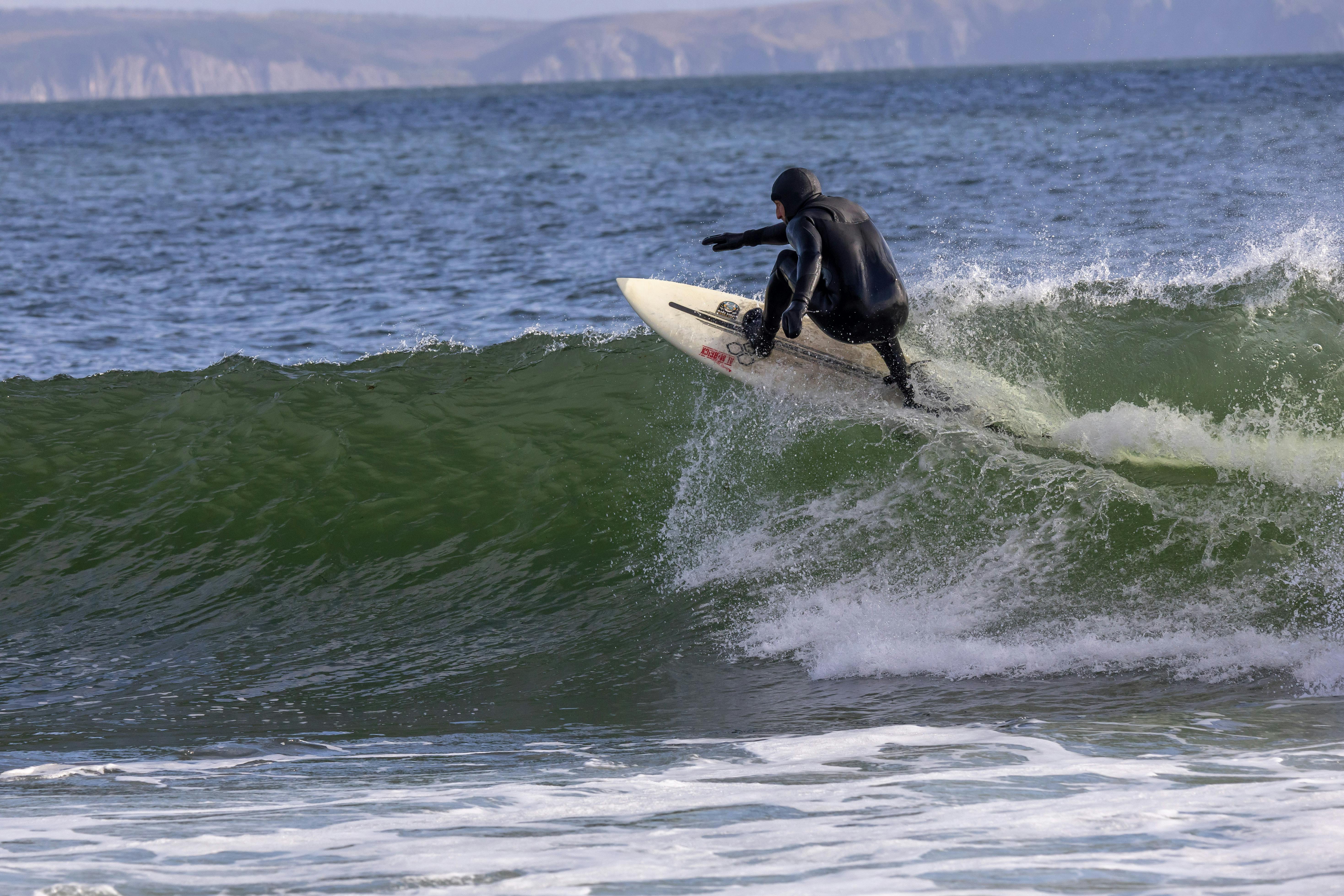 Surfer Riding a Wave in Cold Ocean Waters · Free Stock Photo
