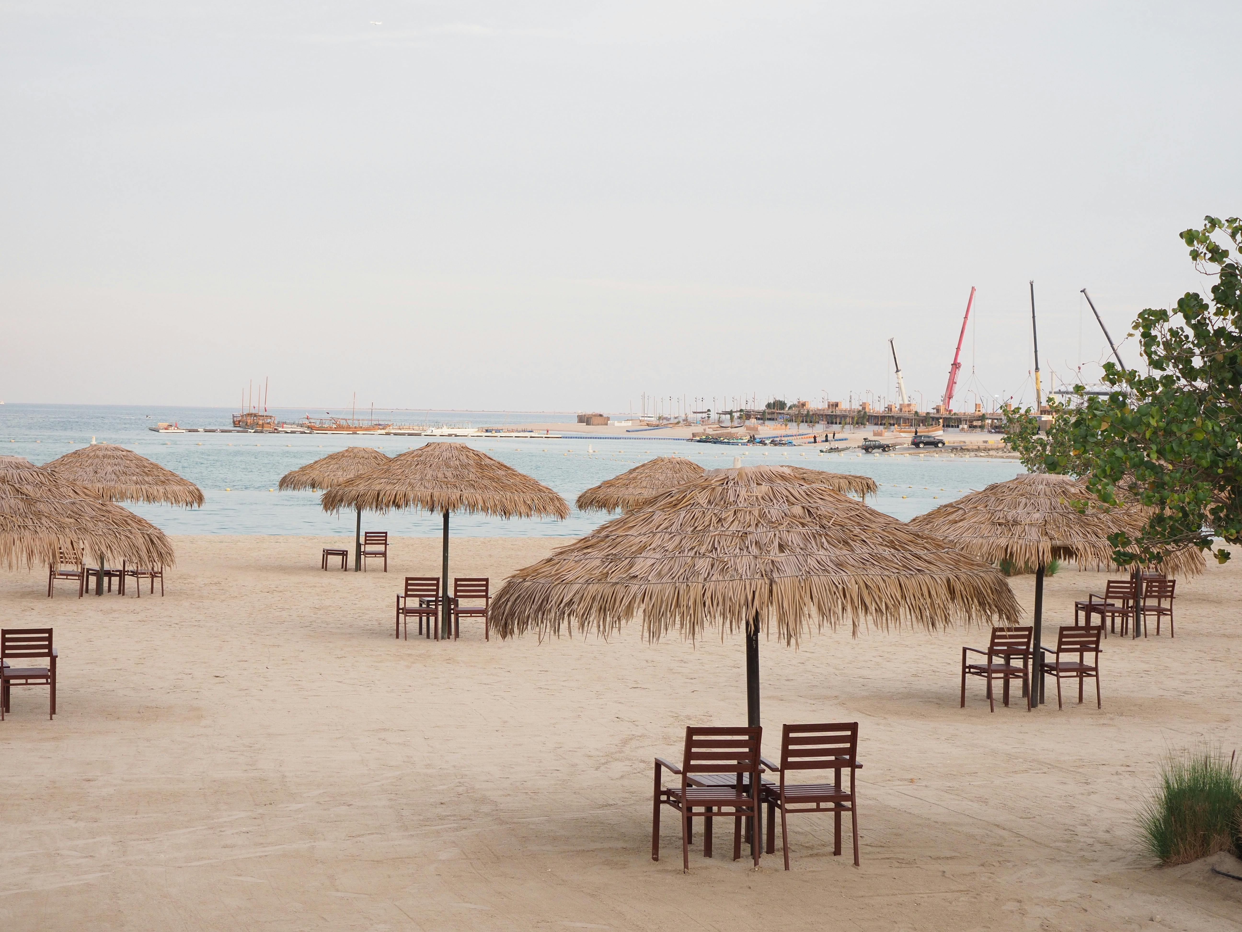 Tranquil Beachfront with Umbrellas in Doha, Qatar · Free Stock Photo