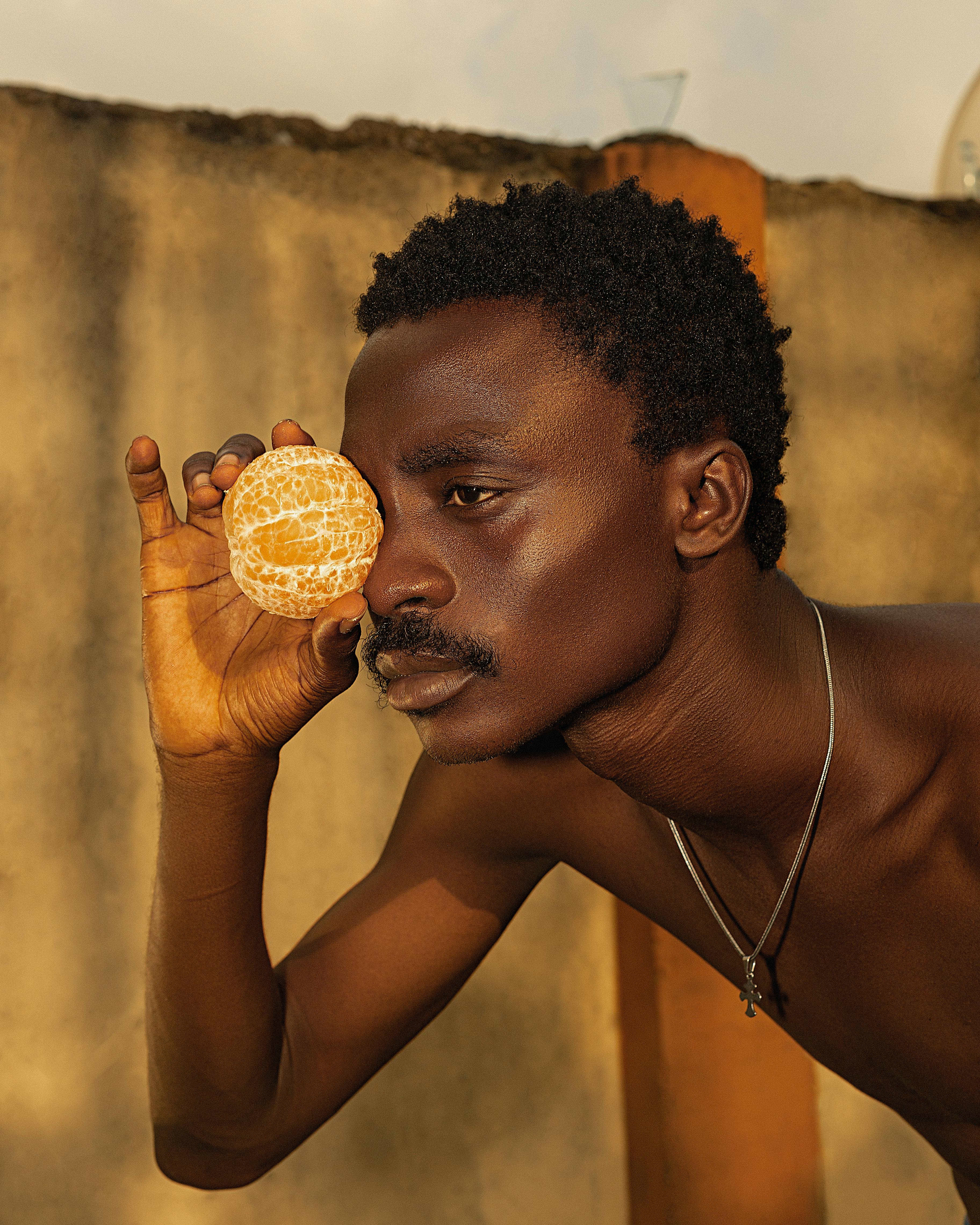 Creative Portrait of Man with Orange · Free Stock Photo