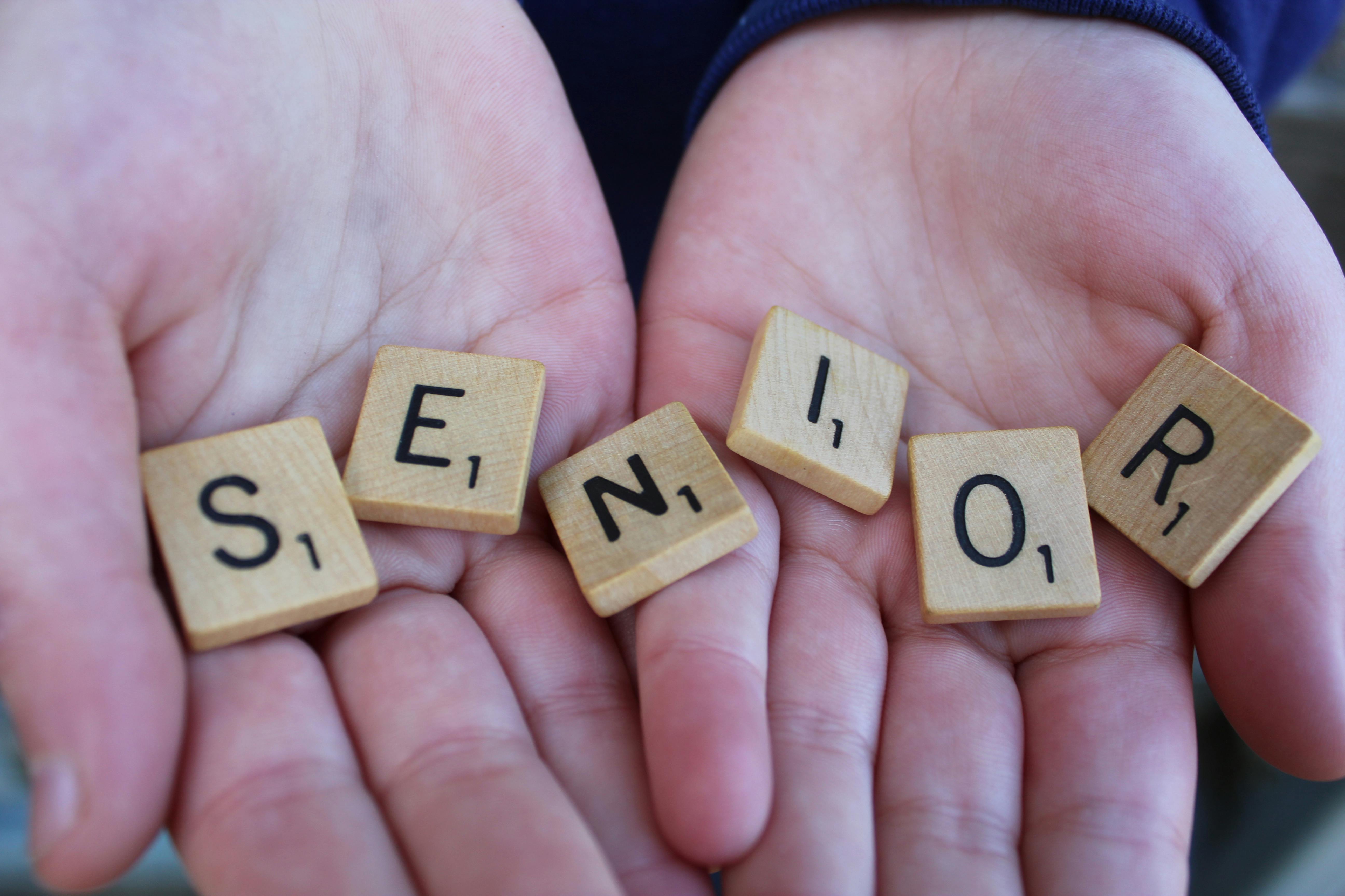 Fichas De Scrabble Para Personas Mayores Sostenidas En Las Manos · Foto ...