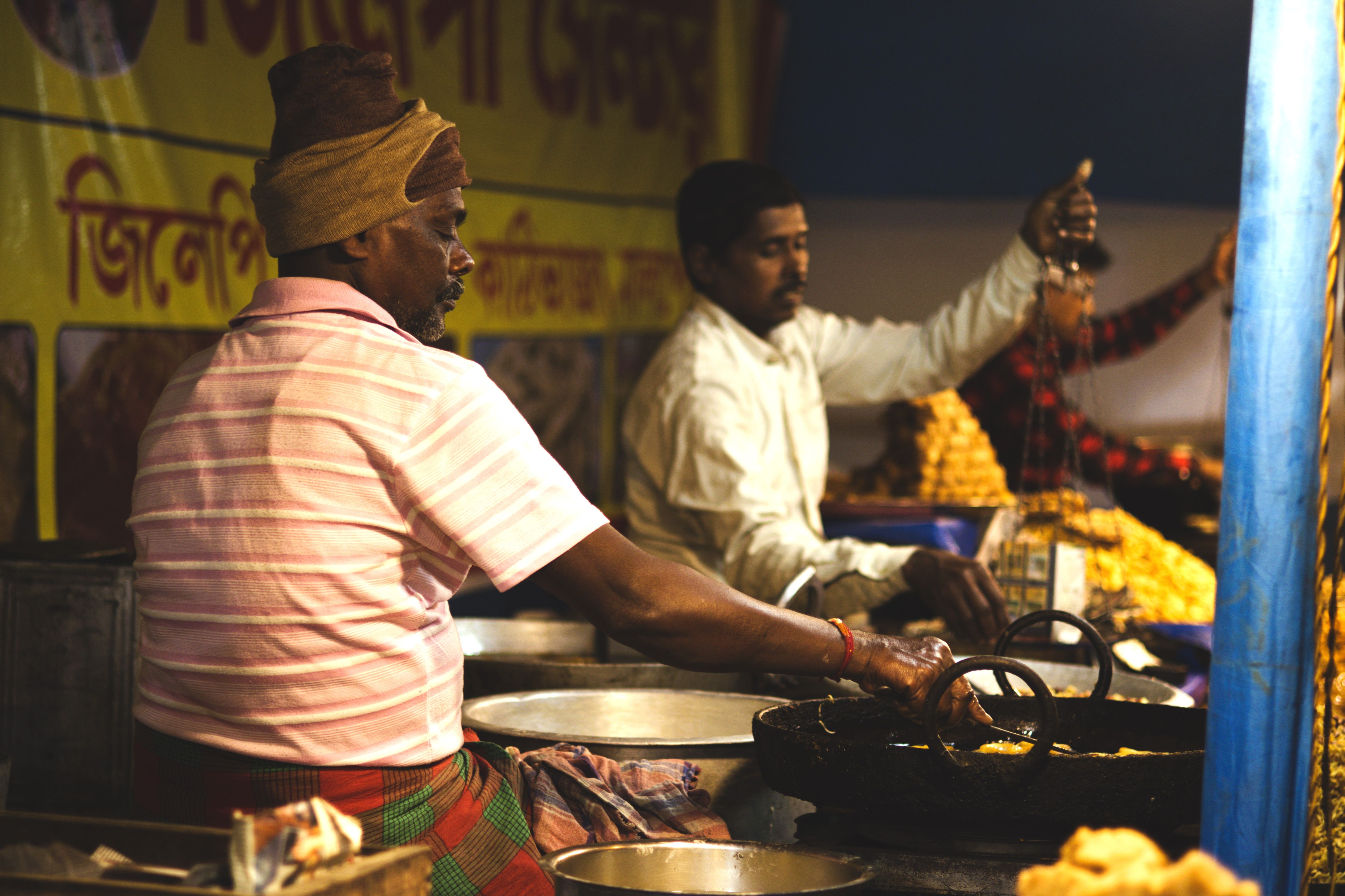 Street Food Vendor Cooking at Night Market · Free Stock Photo