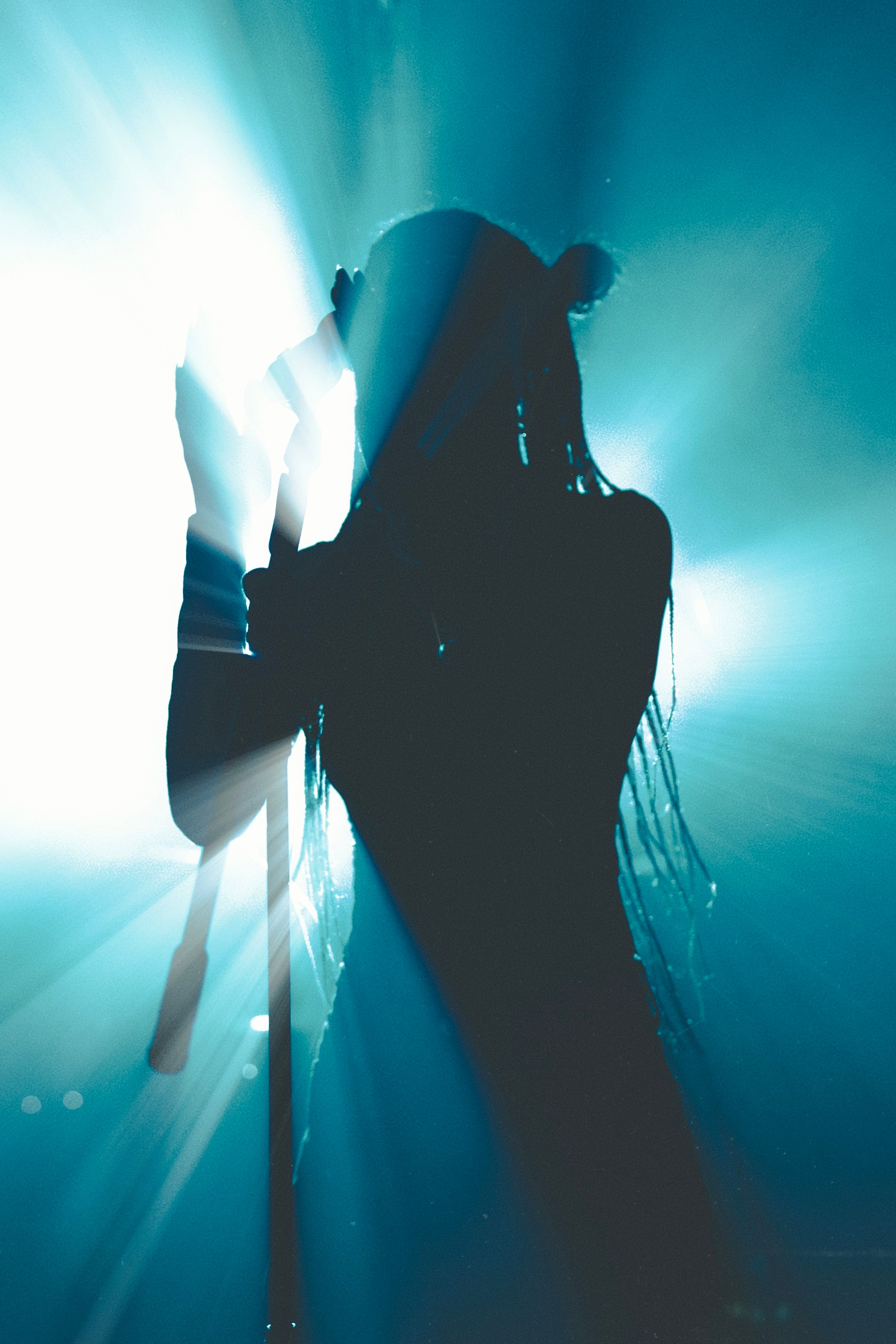 Silhouette of a Performer in Blue Stage Lighting · Free Stock Photo