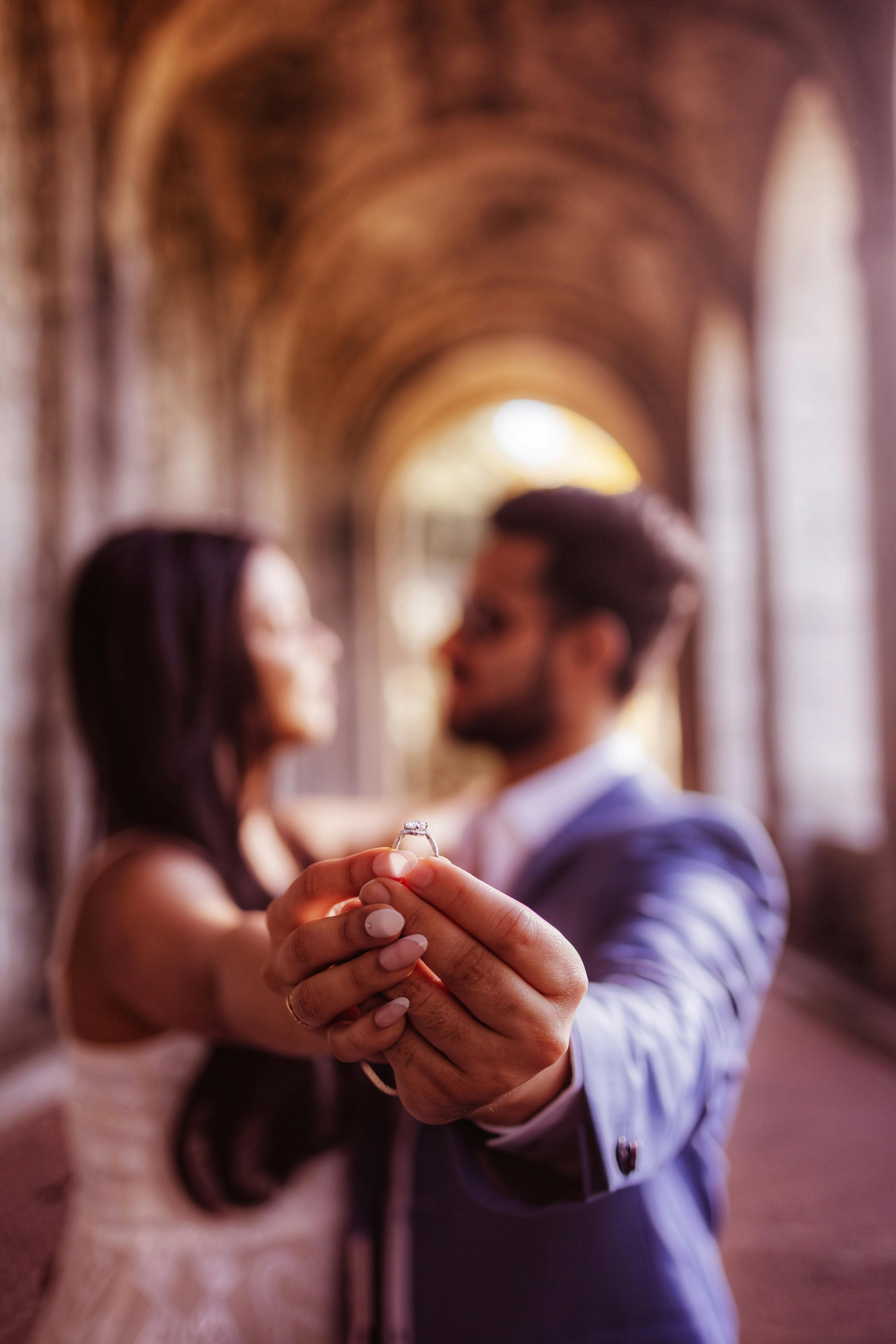 Romantic Engagement Moment Under Arched Pathway · Free Stock Photo