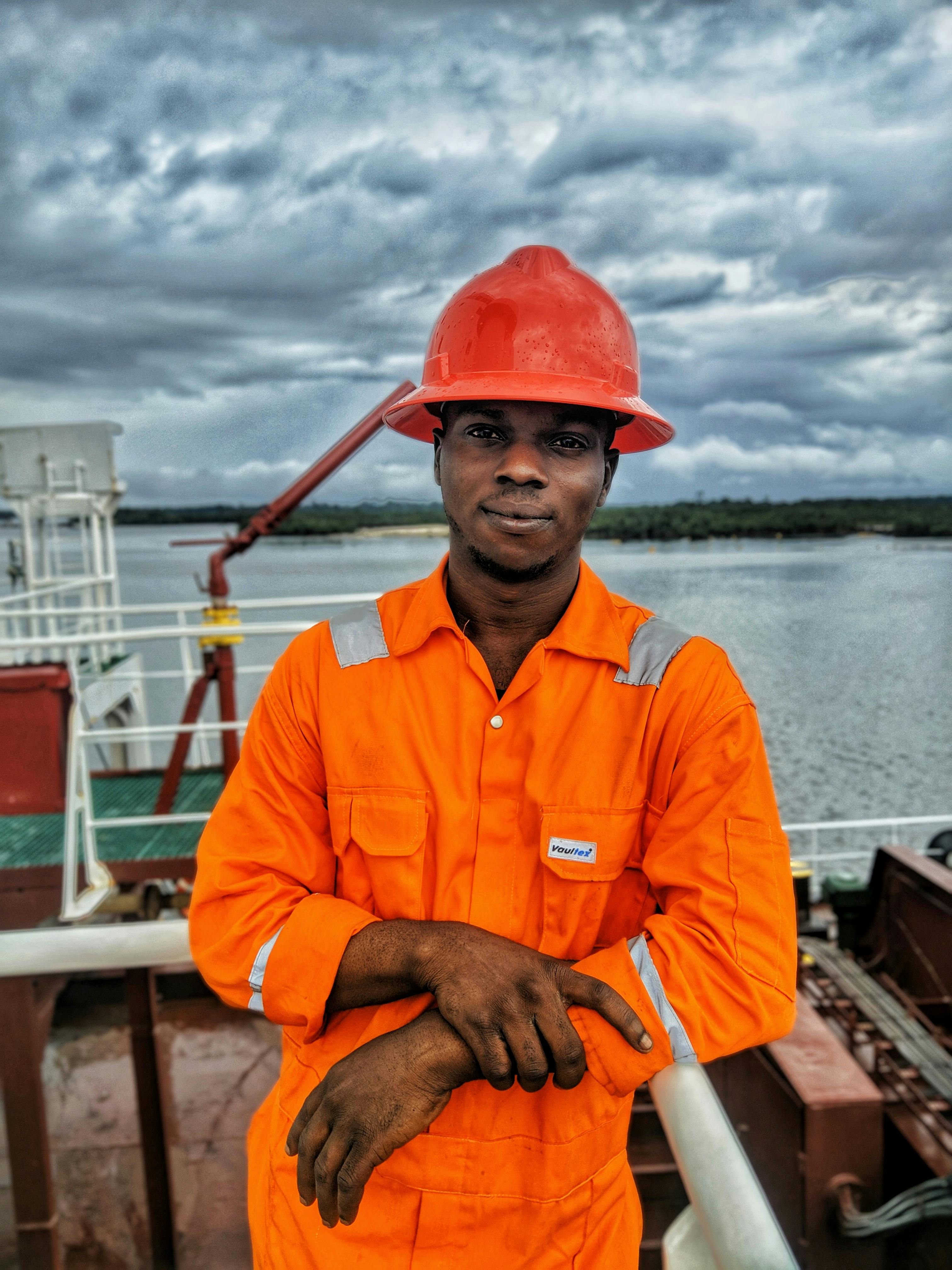 Maritime Worker in Orange Uniform on Ship Deck · Free Stock Photo