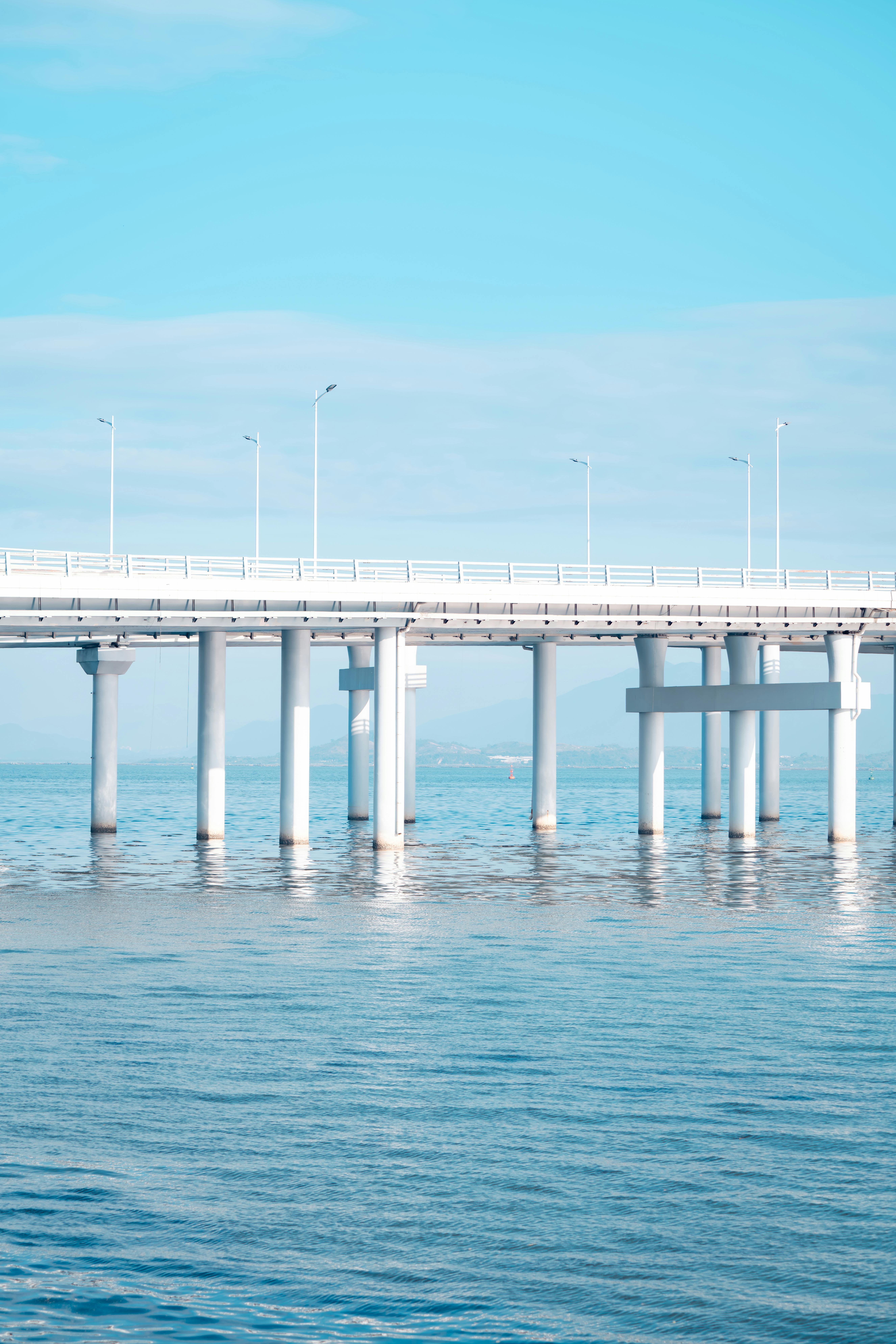 Elegant Bridge Over Calm Blue Ocean Waters · Free Stock Photo