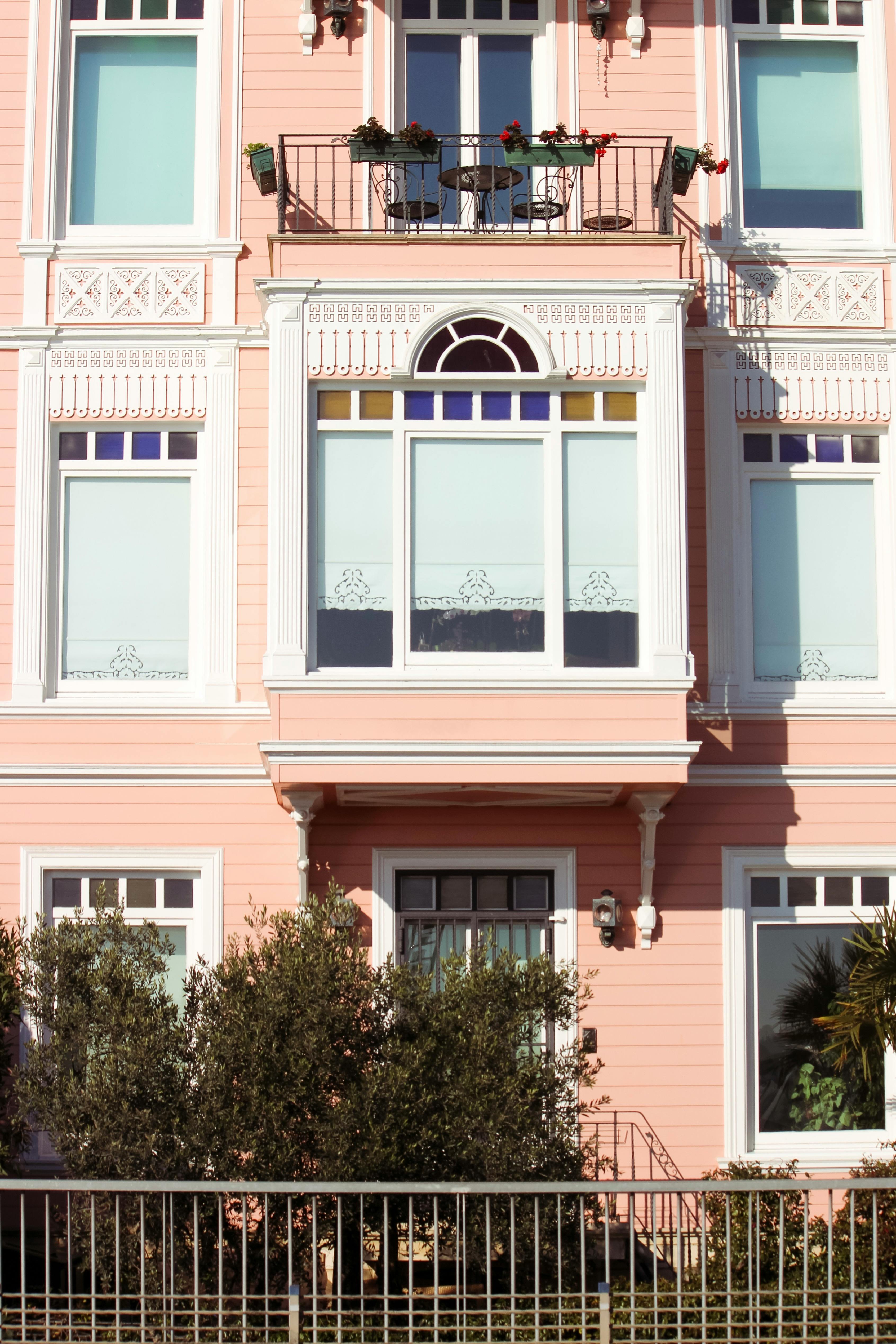 Charming Pink Victorian House Facade with Balcony · Free Stock Photo
