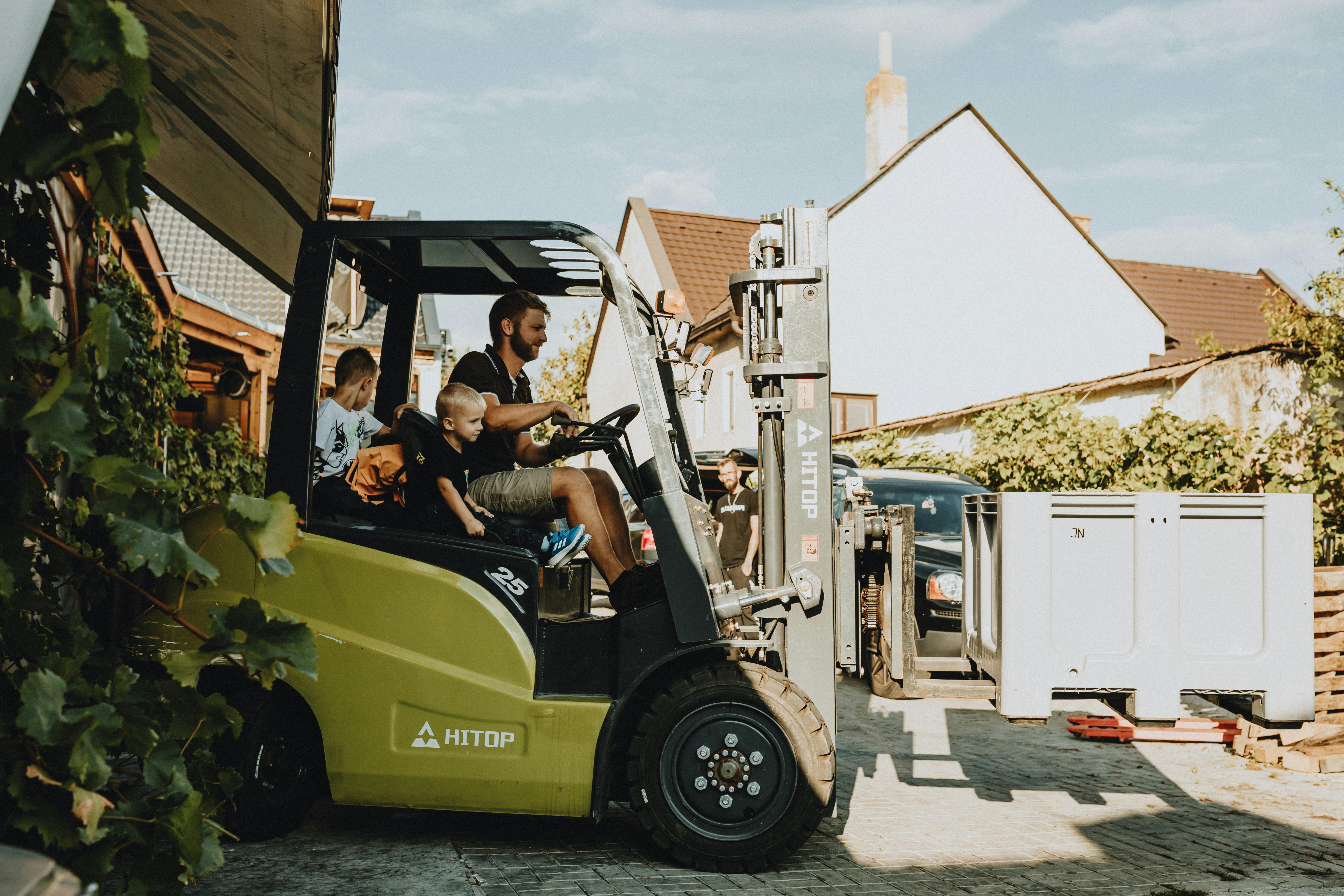 Family Enjoying a Ride on a Forklift Outdoors · Free Stock Photo
