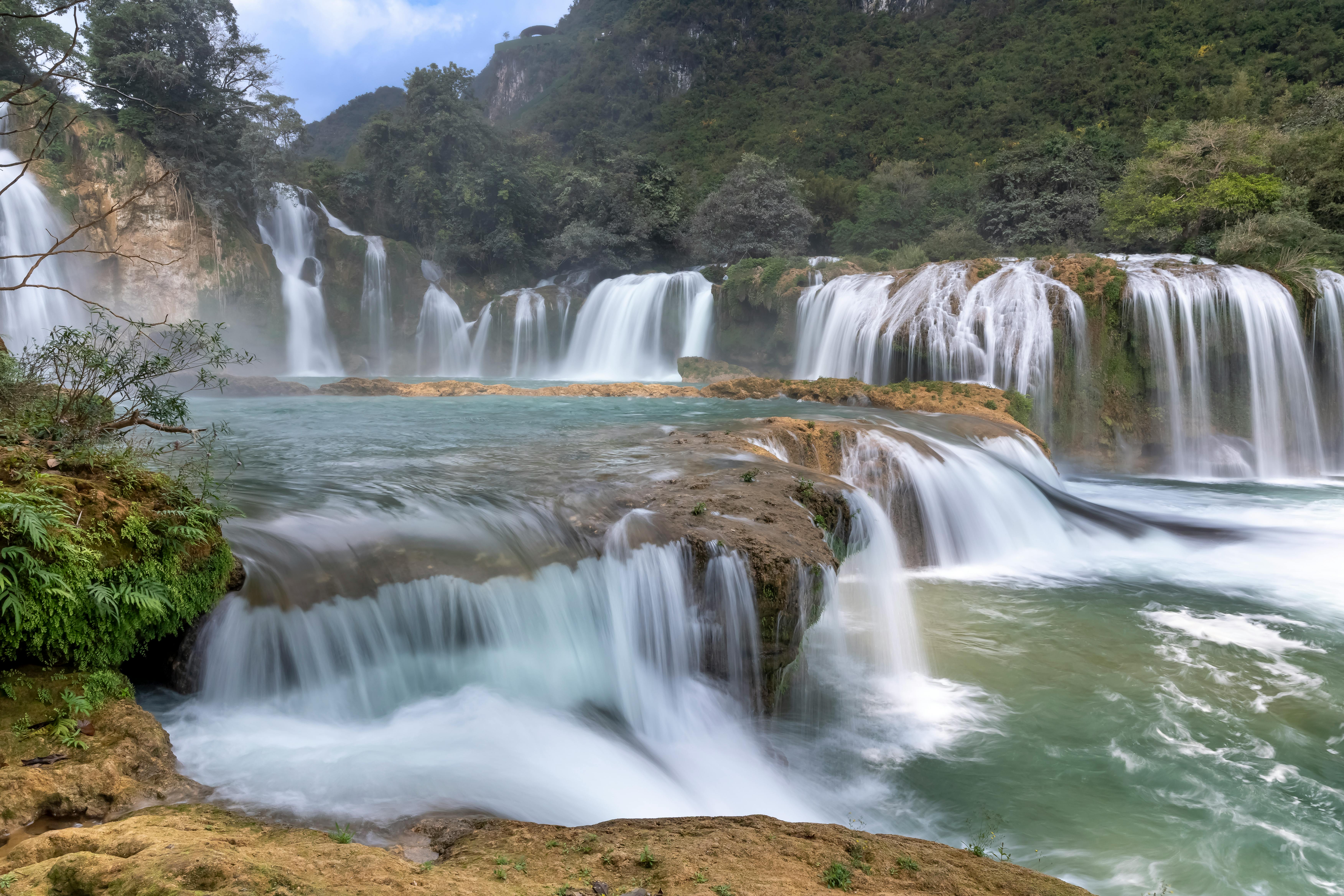 Waterfalls Beside Green High Trees Under White Sky at Daytime · Free ...