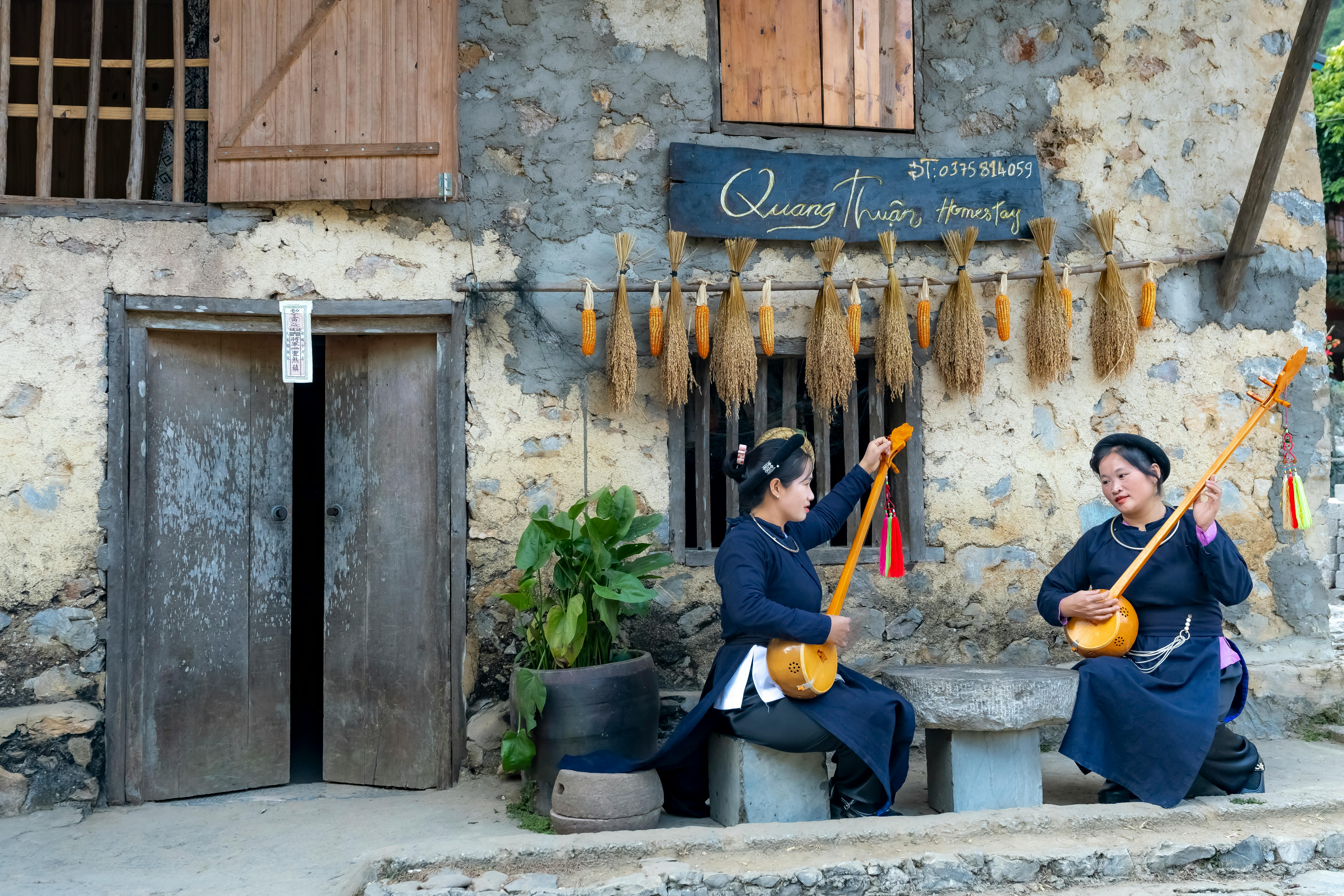 Traditional Vietnamese Musicians in Rustic Setting · Free Stock Photo