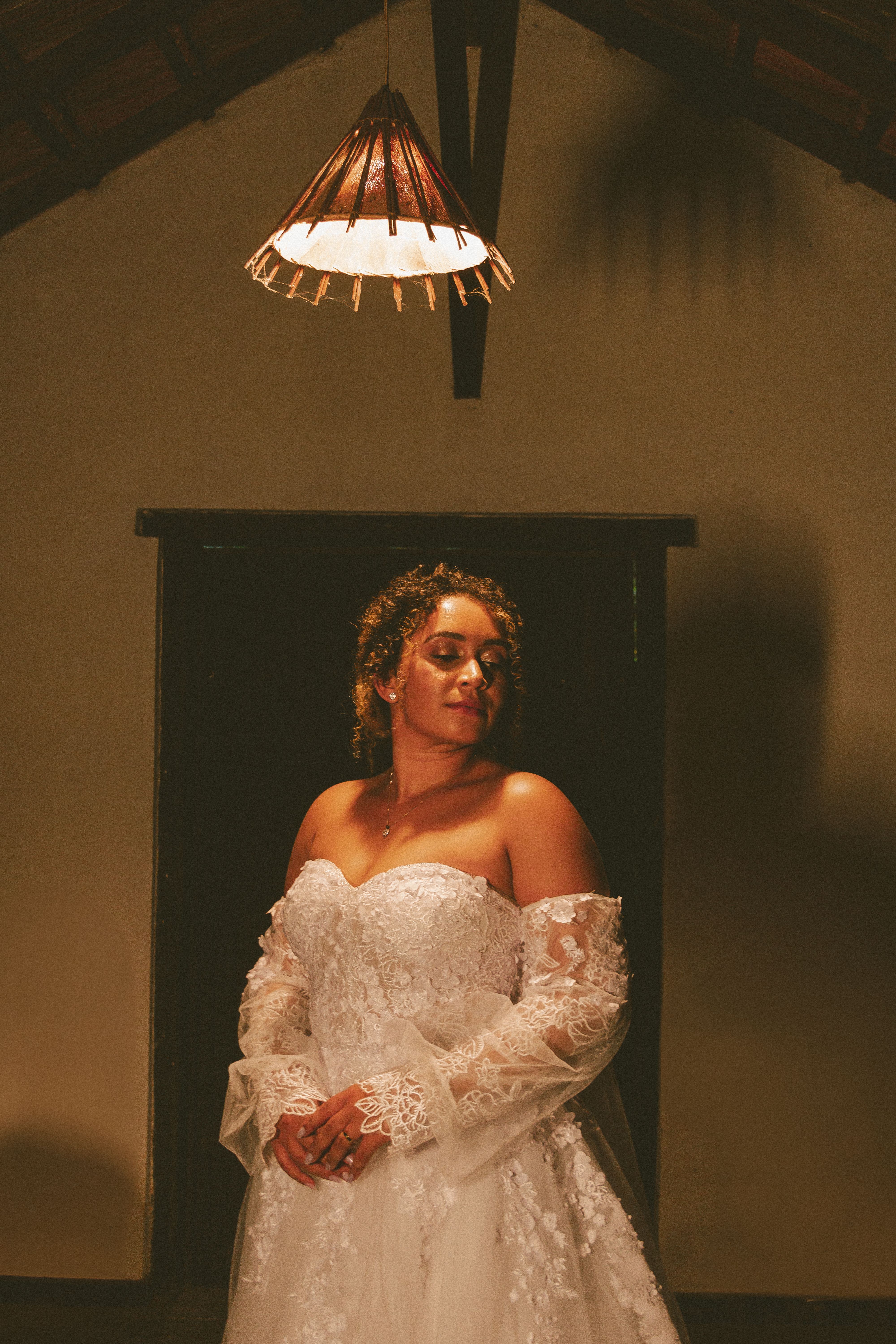 Elegant Bride in Lace Gown Under Warm Lighting · Free Stock Photo