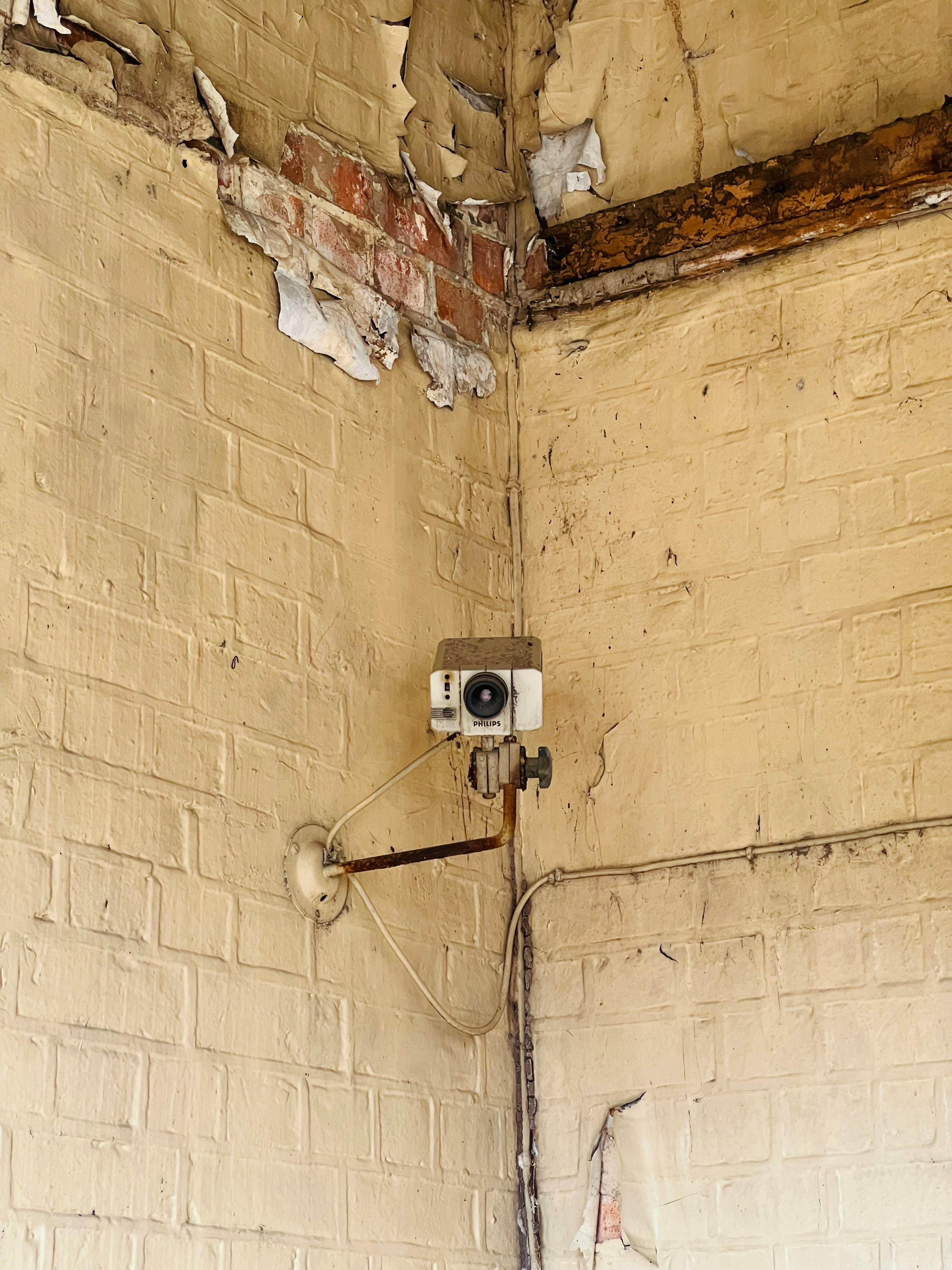 Vintage Security Camera in Abandoned Building Corner · Free Stock Photo