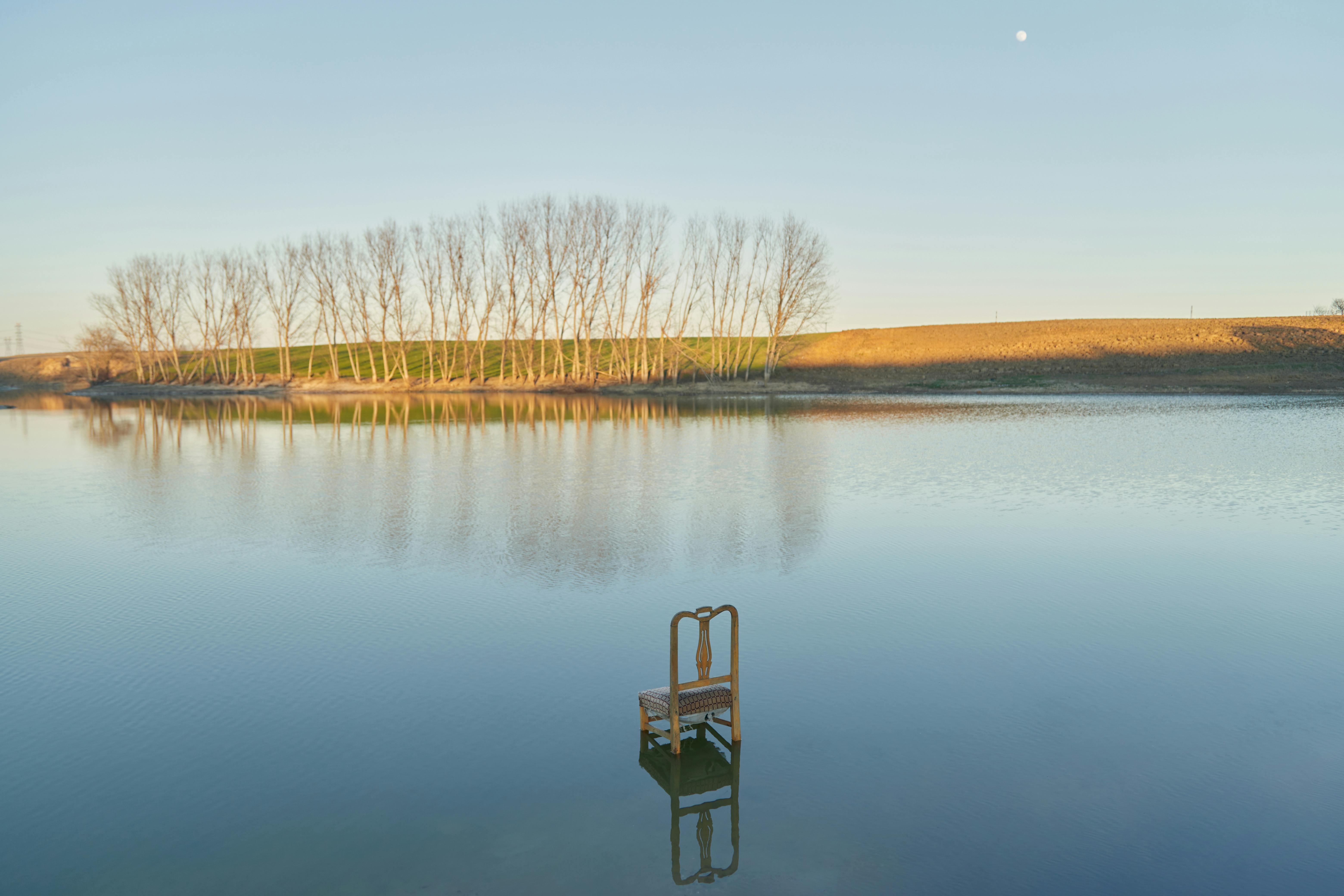 Lone Chair in Tranquil Lake Setting · Free Stock Photo