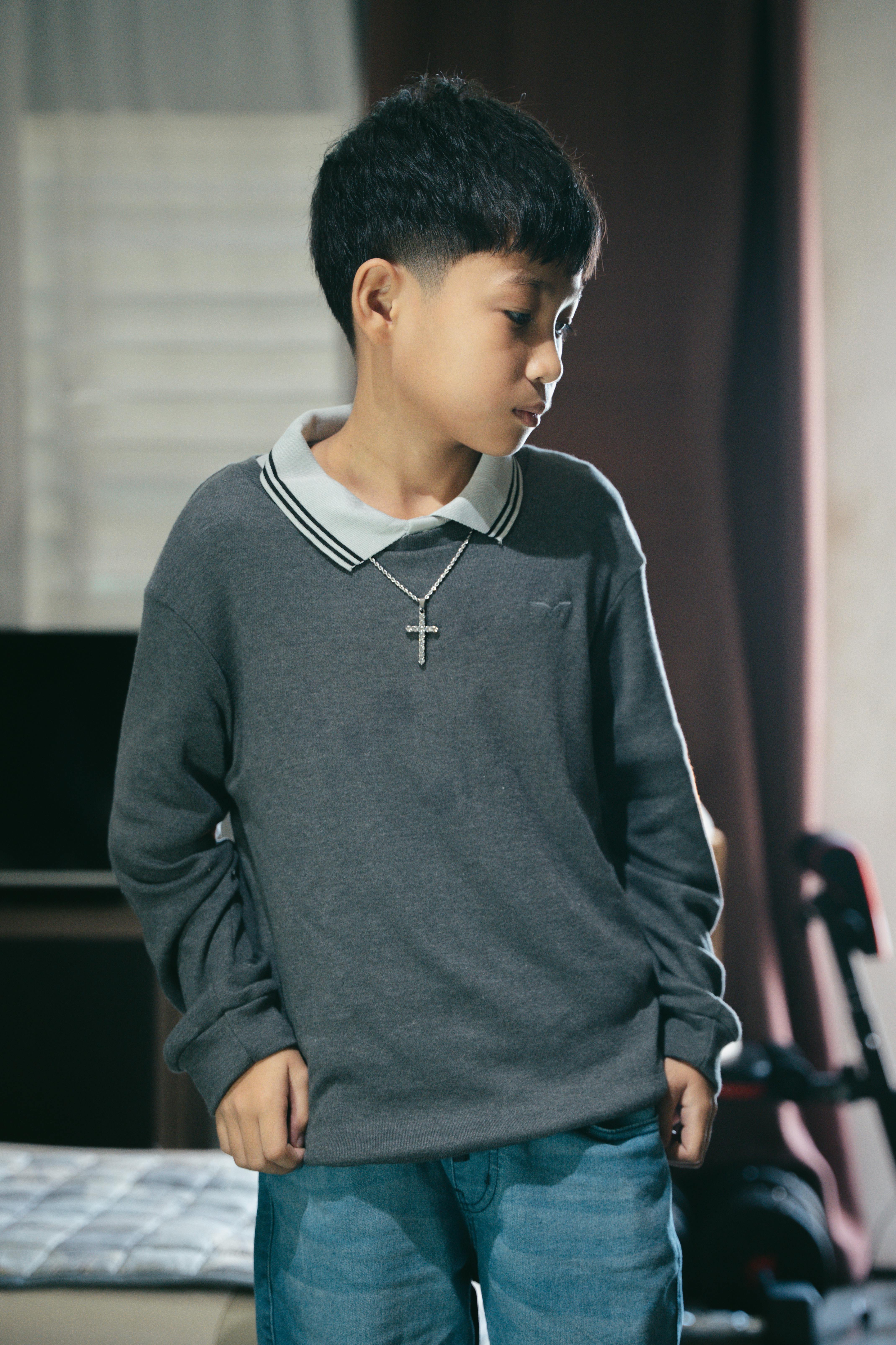 Portrait of a Young Boy with Cross Necklace Indoors · Free Stock Photo