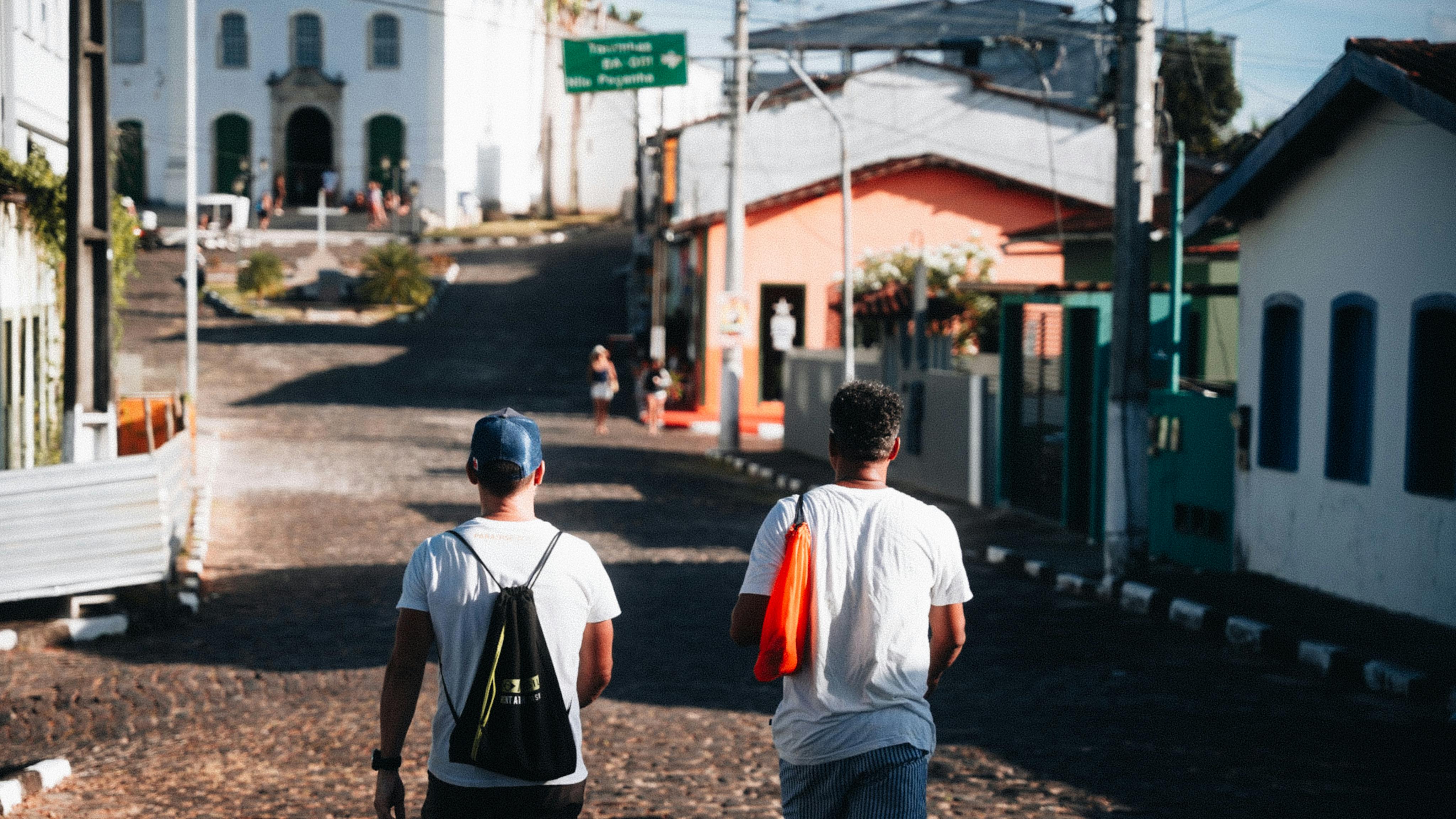 Two people walking down cobblestone street · Free Stock Photo